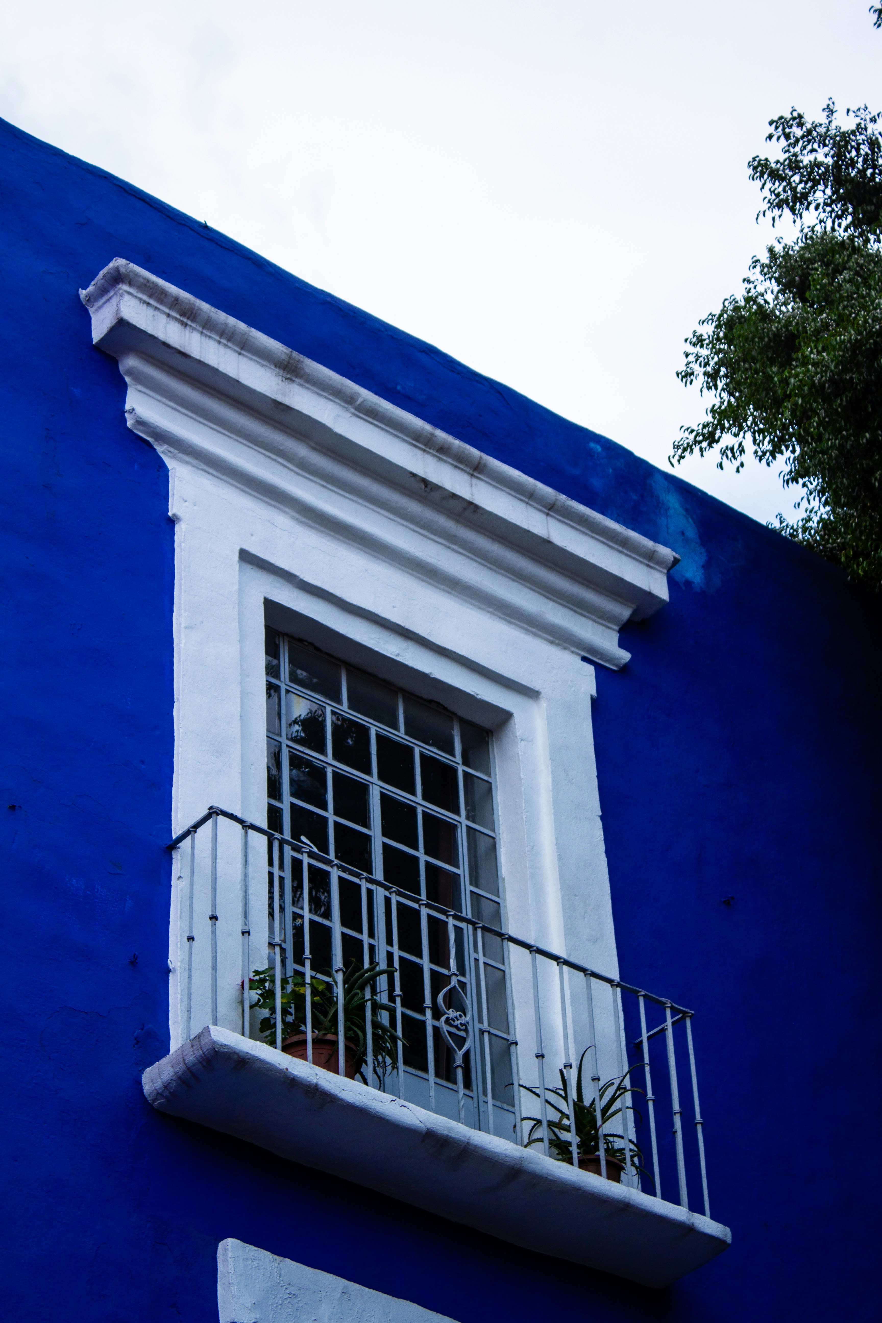 Azure Facade and Balcony: A Quiet Blue Wall with White Framing