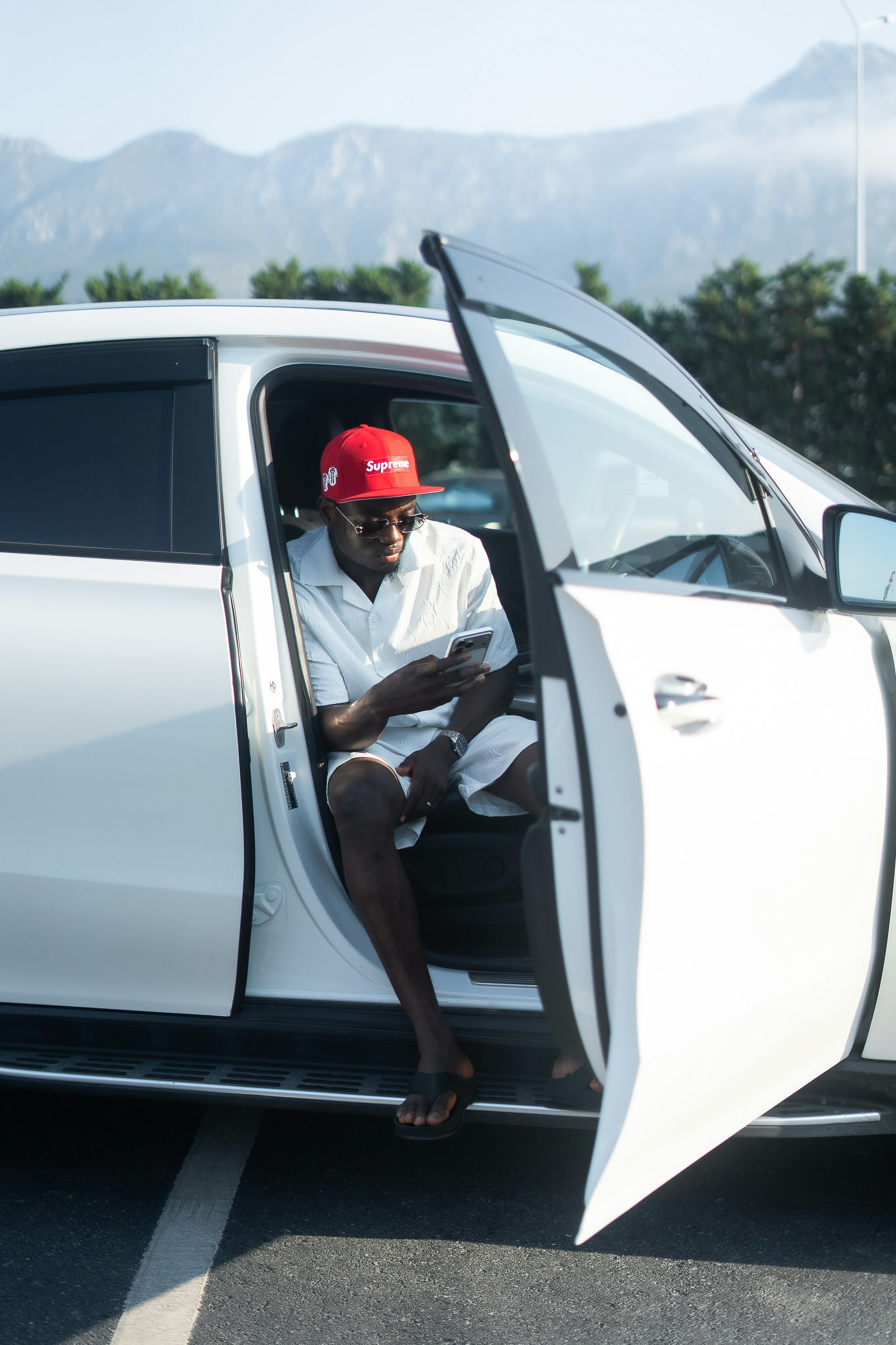 Passenger in White SUV Desk: A Quiet Moment with a Red Cap