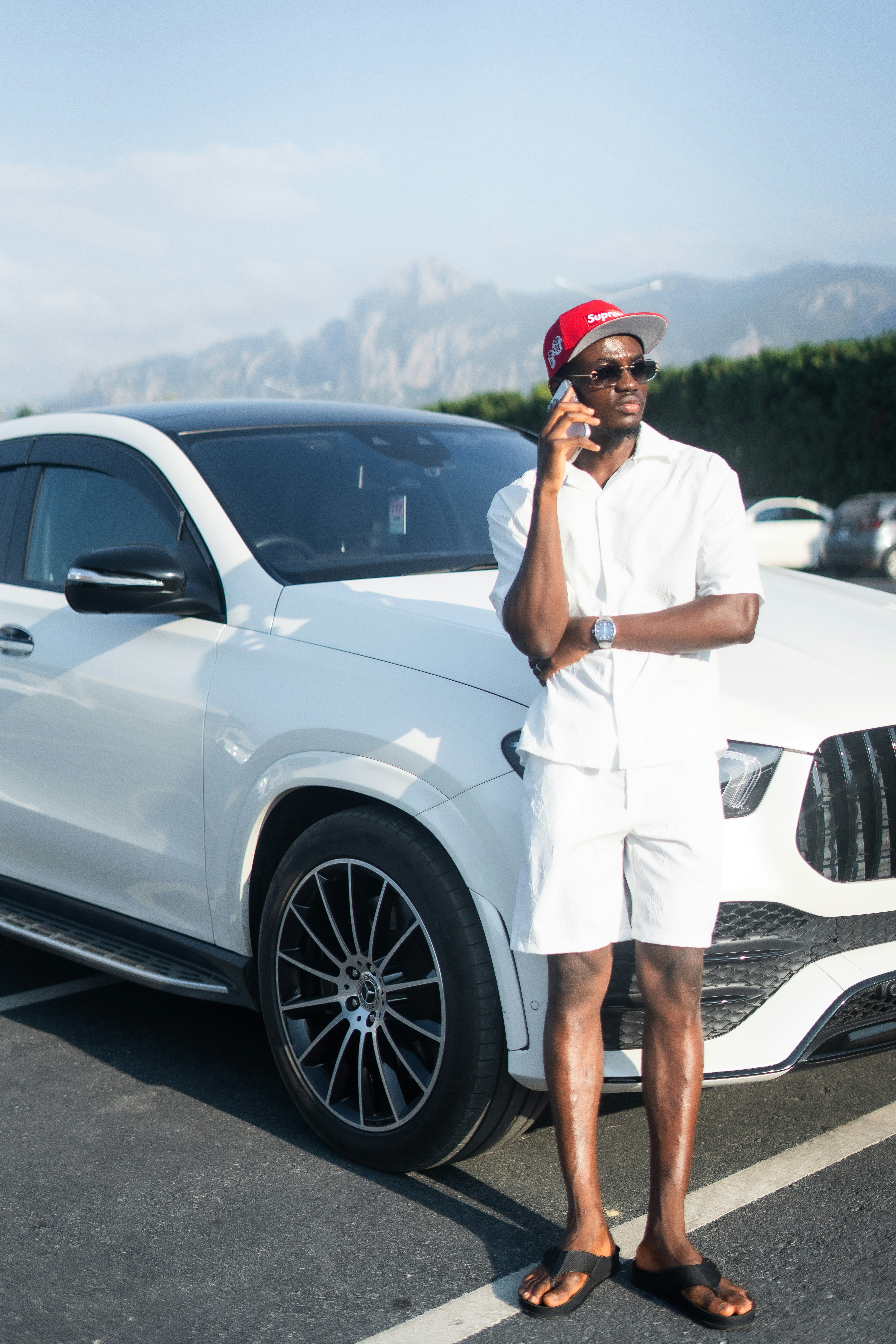 White-Suited Portrait by the Car: A Relaxed Moment in the Parking Lot