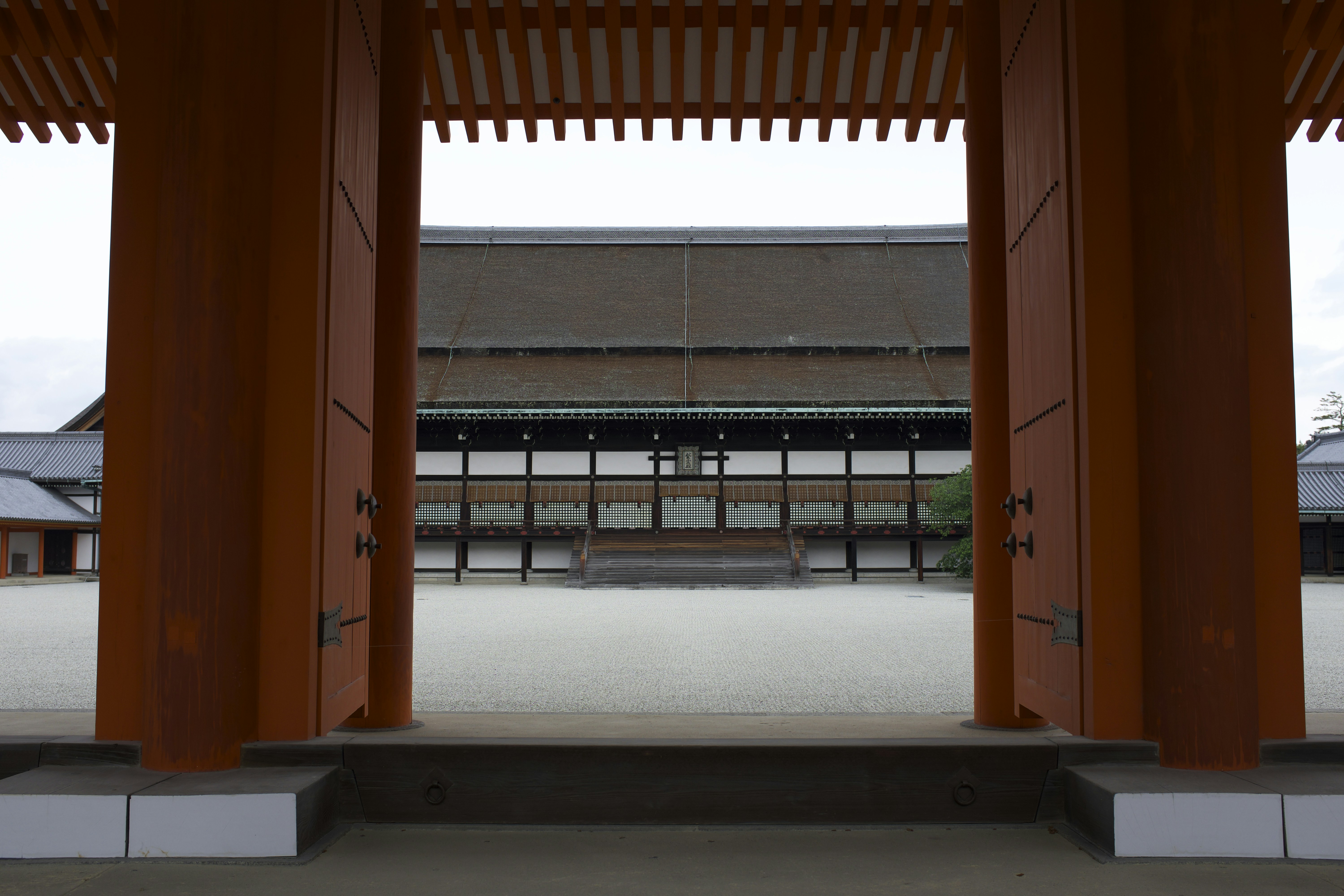 Symmetry Under Red Columns: A Peaceful Gateway to the Courtyard