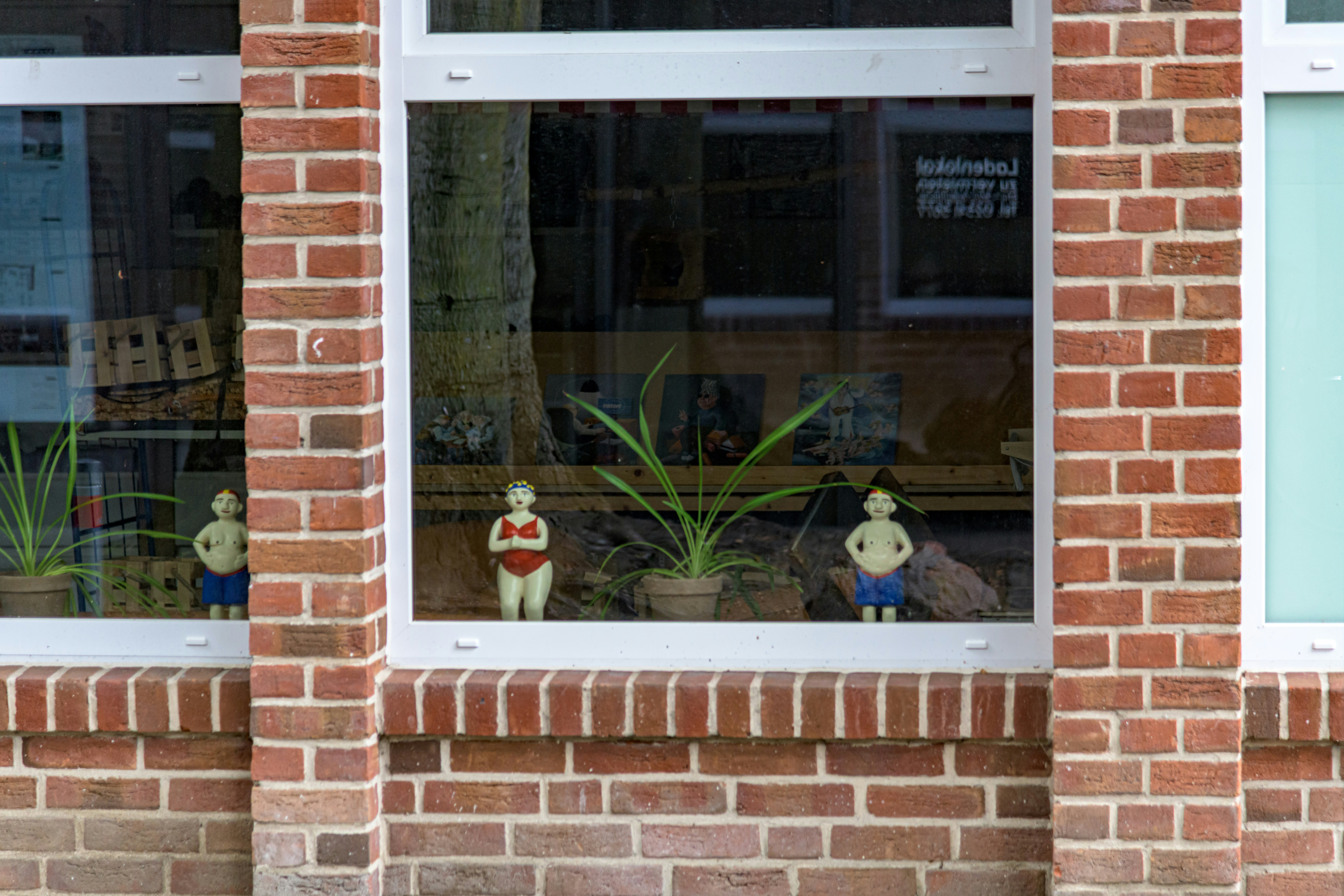 Tiny Garden Characters Guard a Brick Window