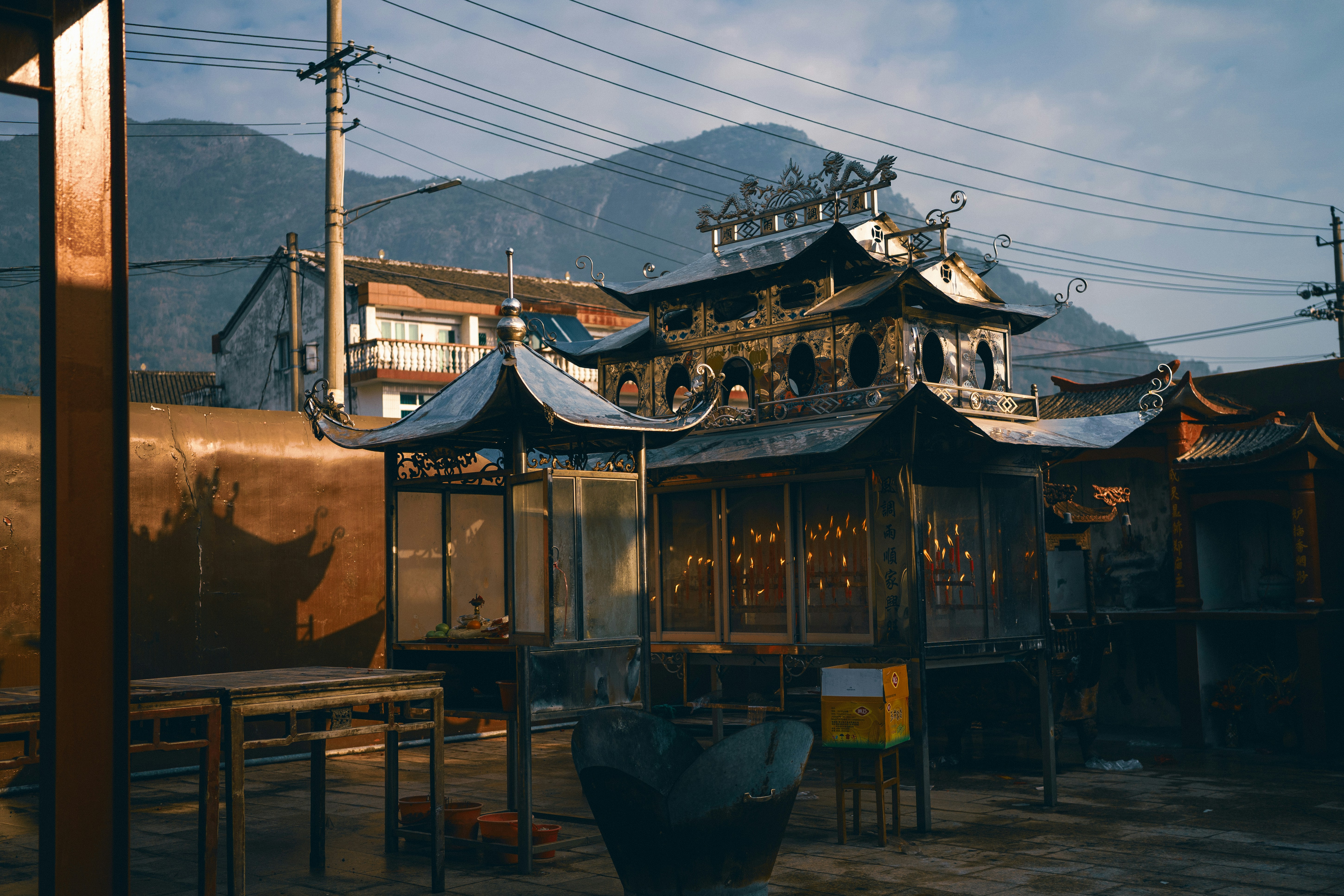 Ornate asian temple buildings against a mountain backdrop.