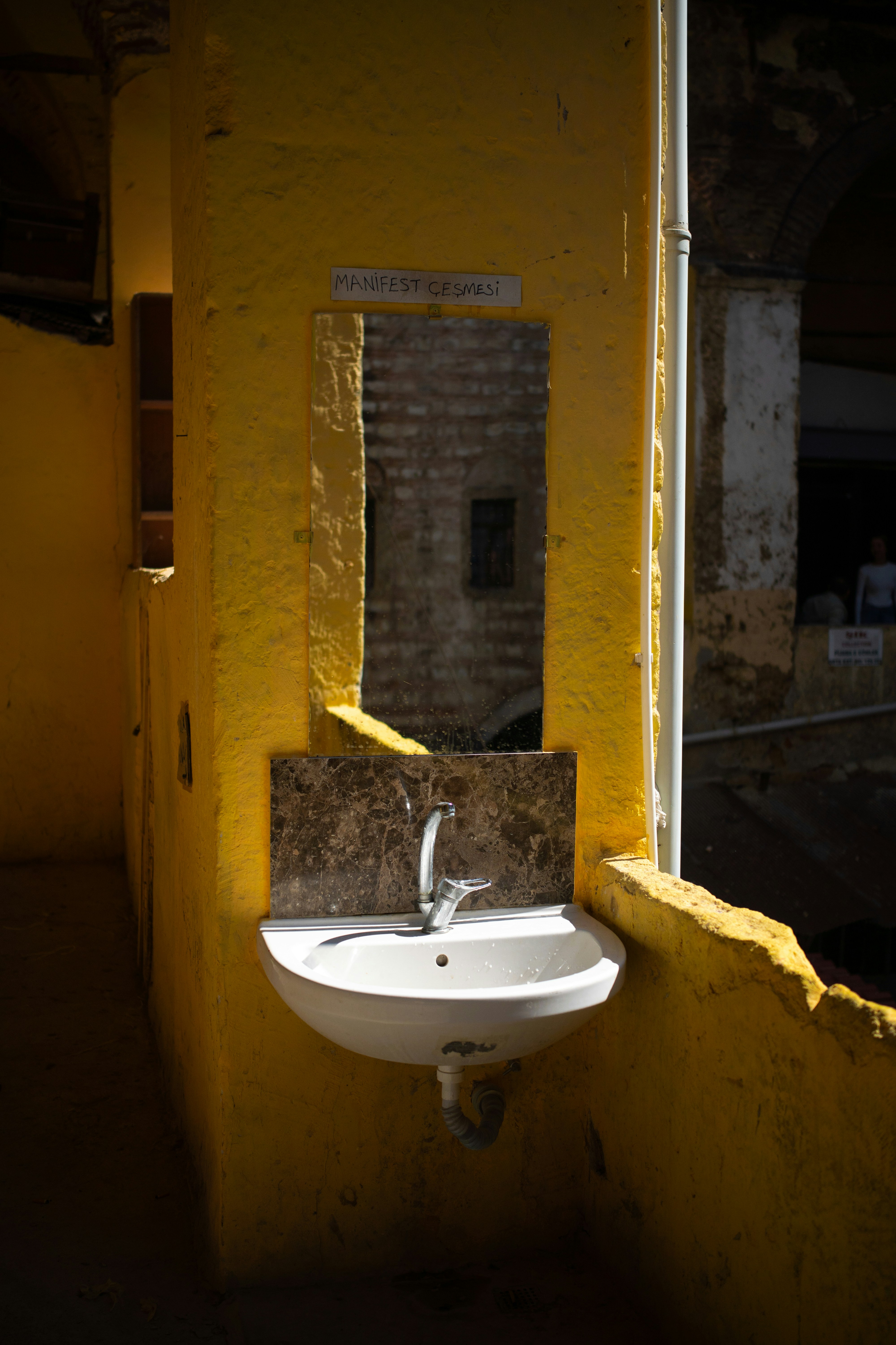 Yellow Archway with Pedestal Sink in Dappled Light