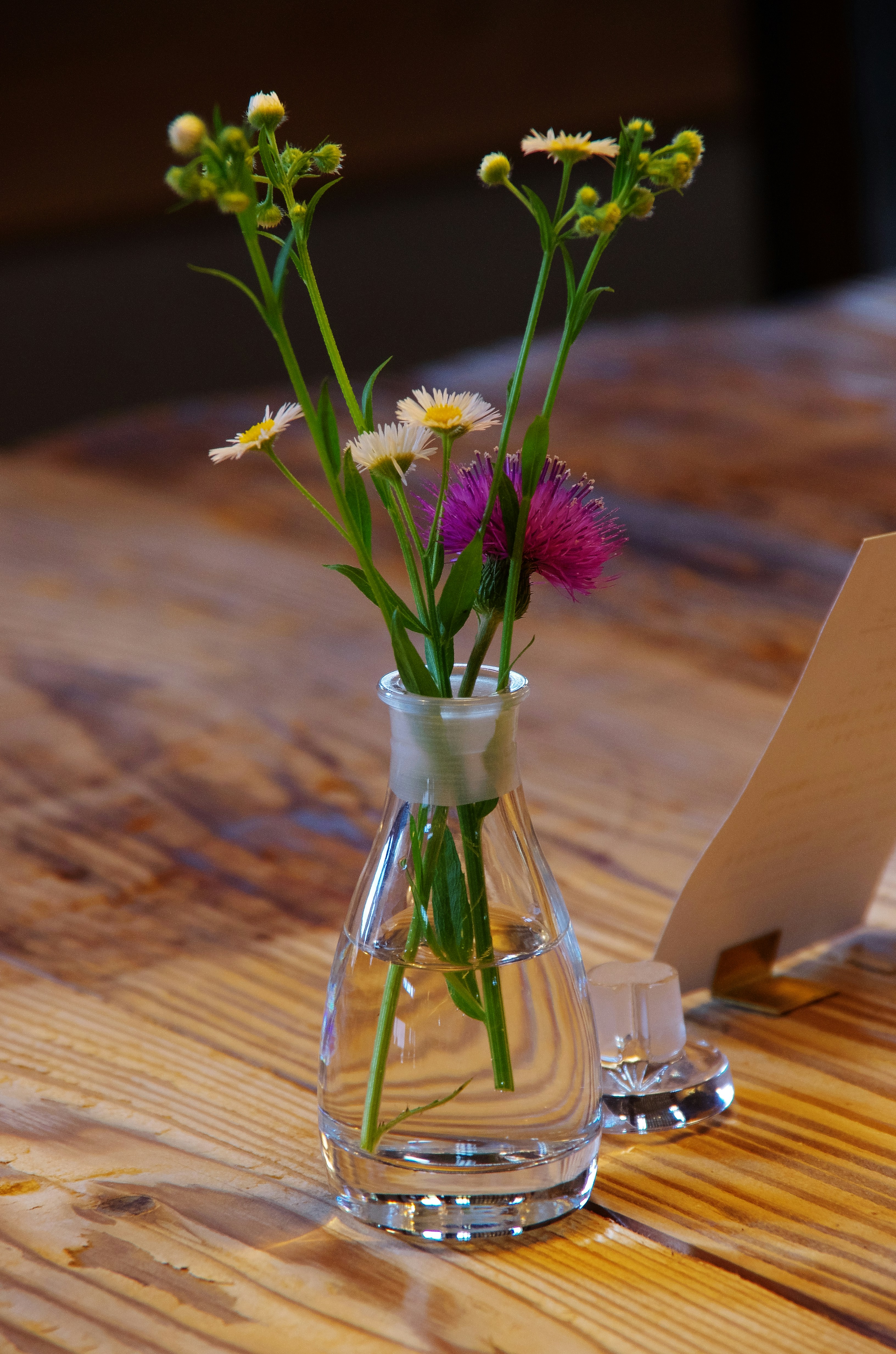 Glass Vase of Wildflowers on a Rustic Wooden Table