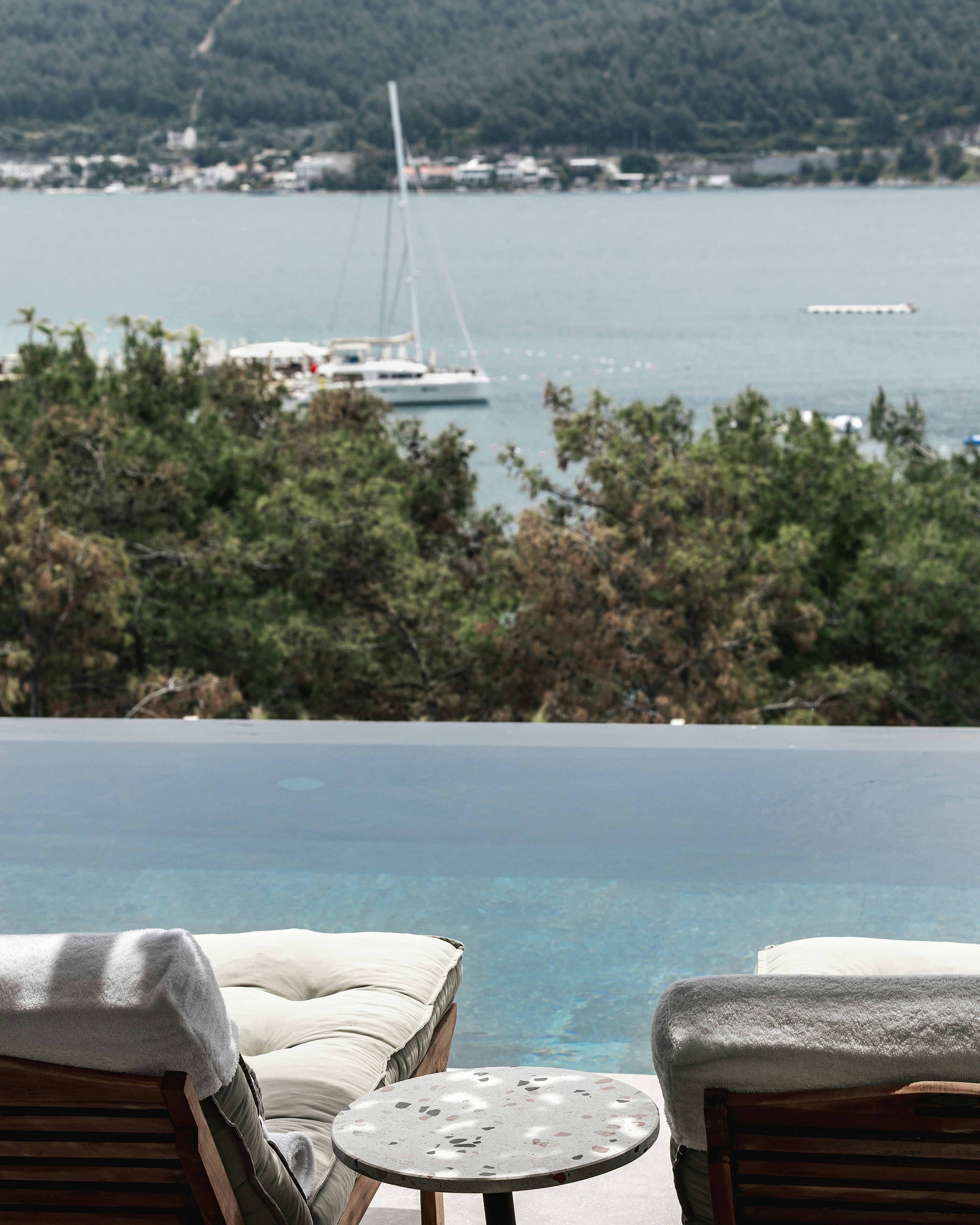 Lounge chairs by an infinity pool overlooking the ocean.