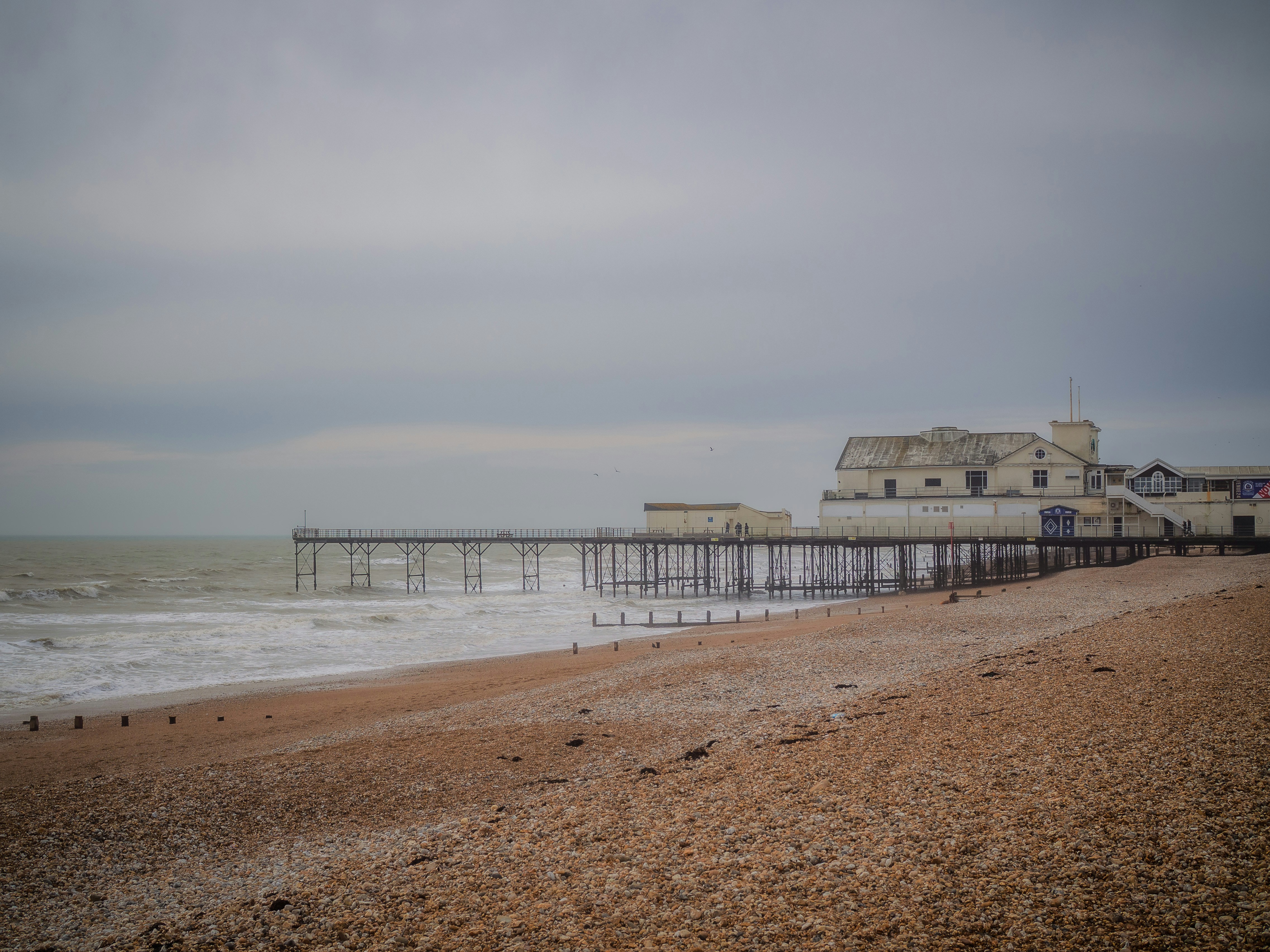 Pier and Weathered Huts Over the Quiet Sea