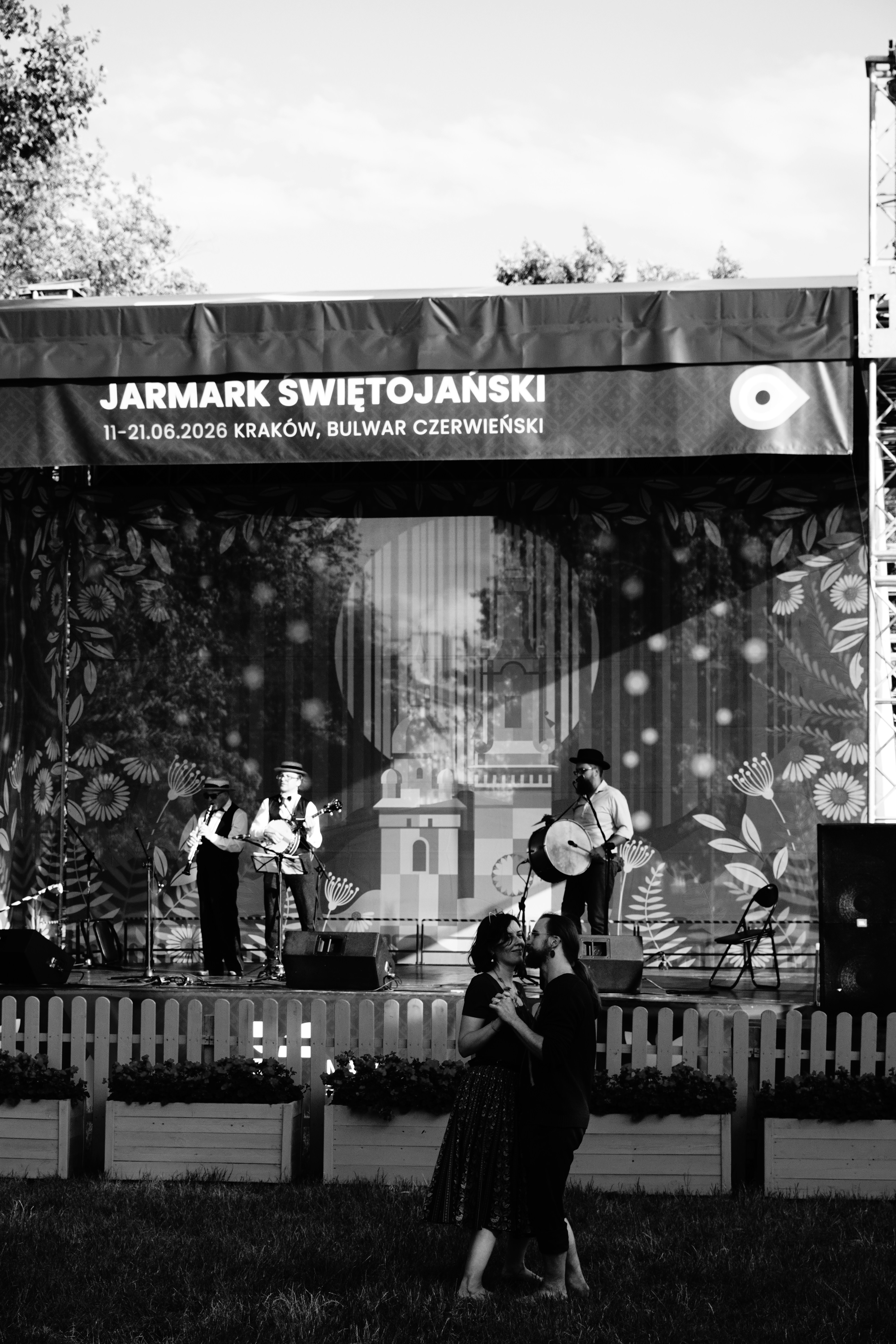 Stagefront Serenade: A Quiet Moment Beneath Floral Backdrops