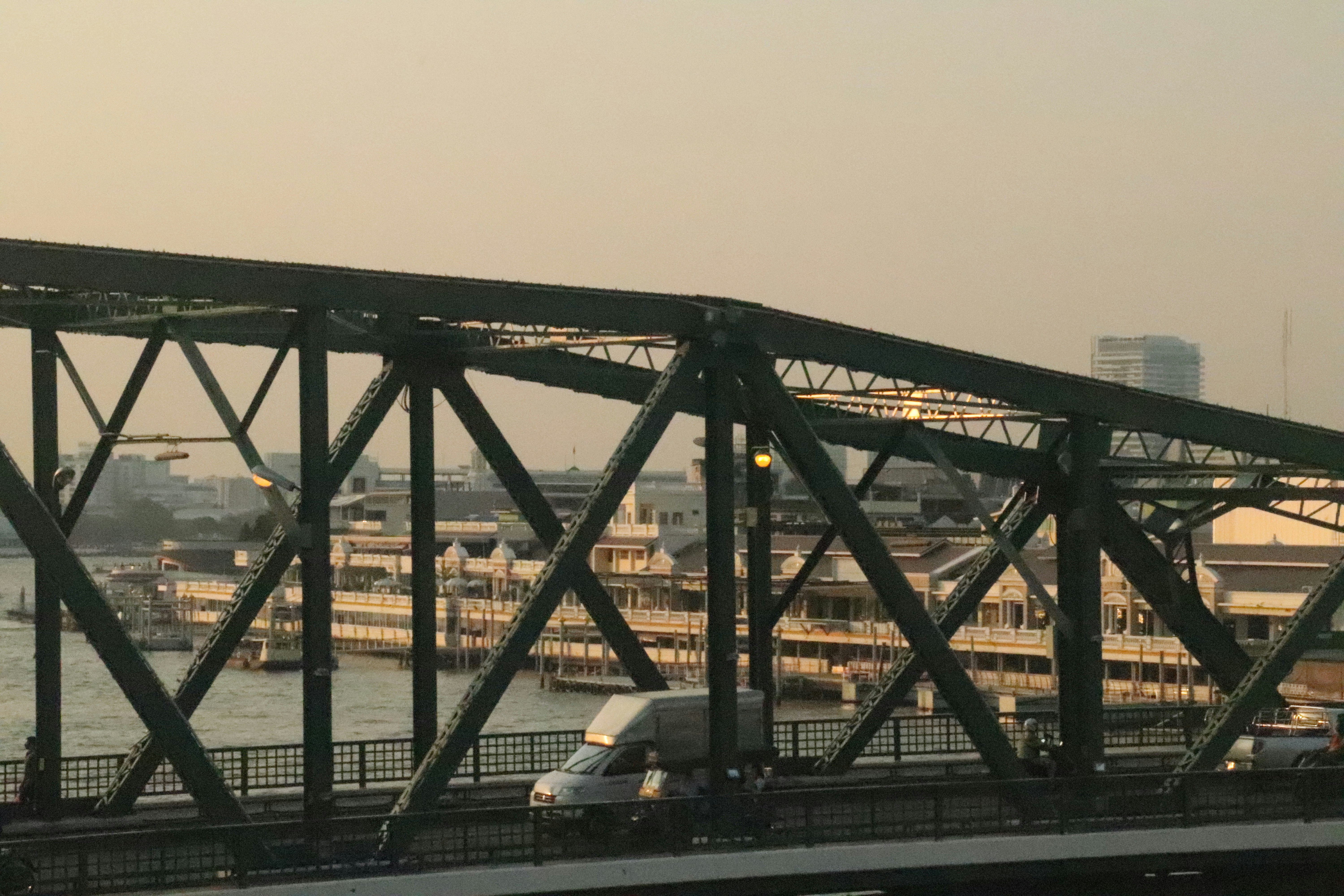 Diesel-blue river crossing: a steel arched bridge under warm evening light