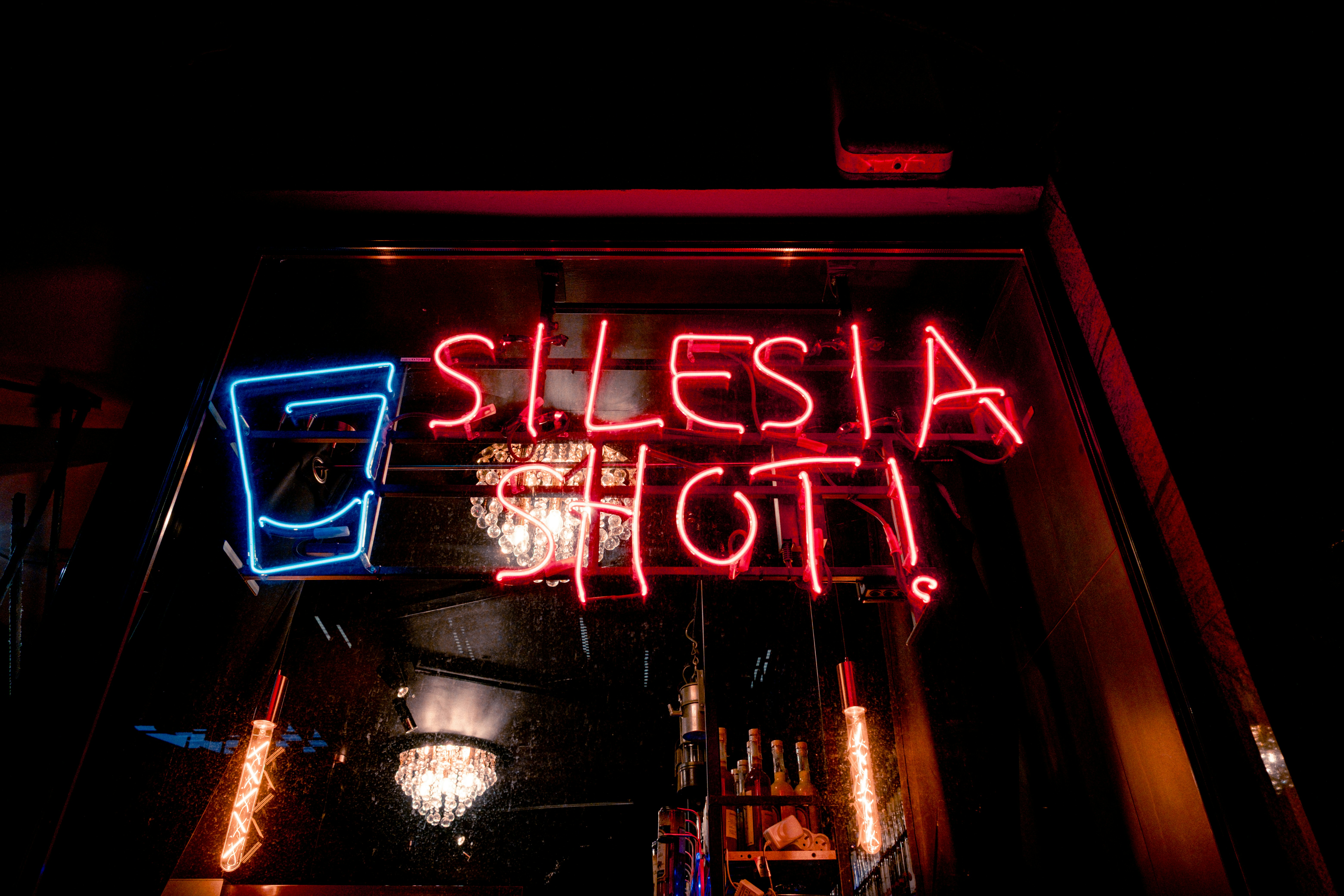 Neon Sign Reflections in a Dark Bar Window