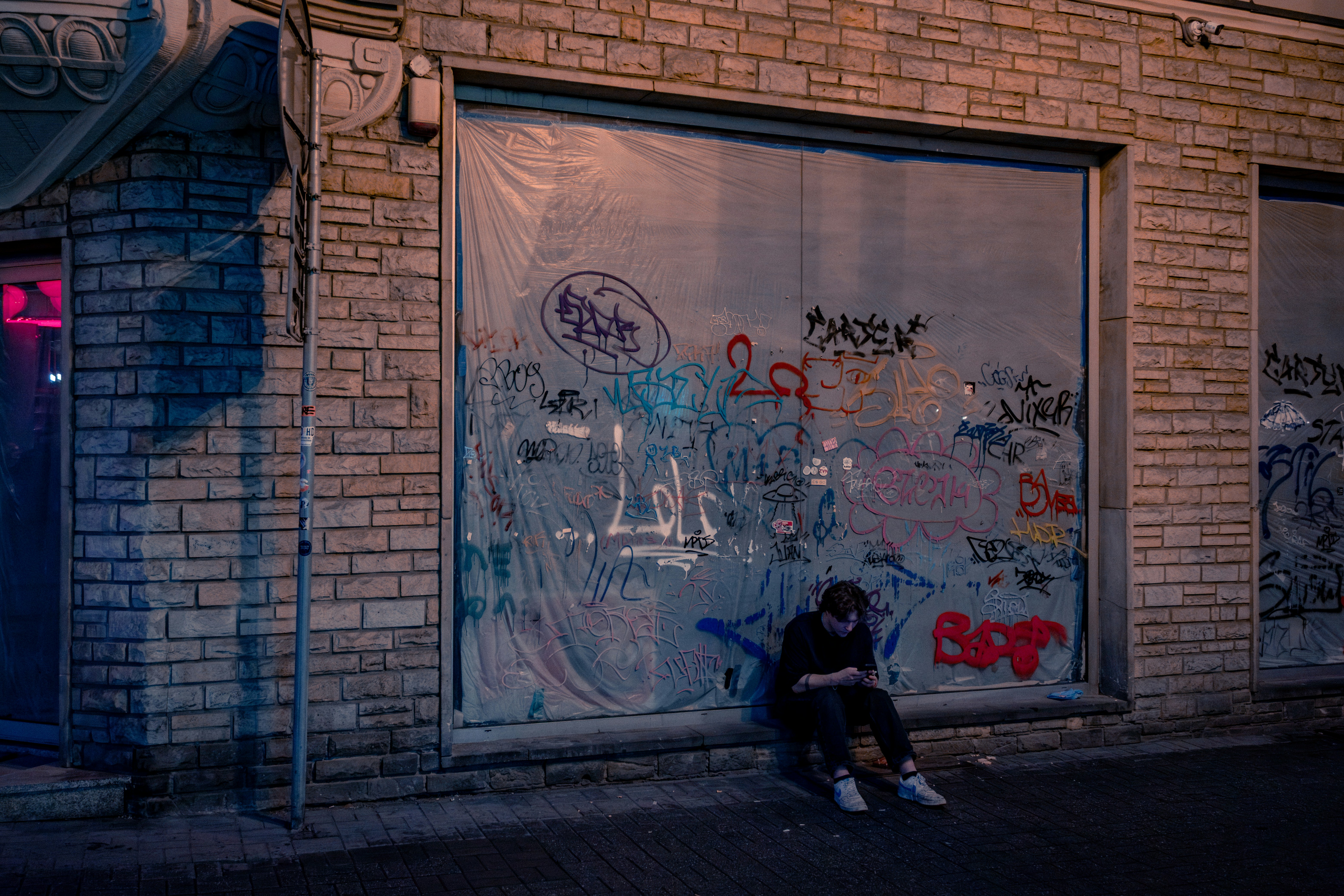 Graffiti Facade: A Quiet Moment Behind the Night Light