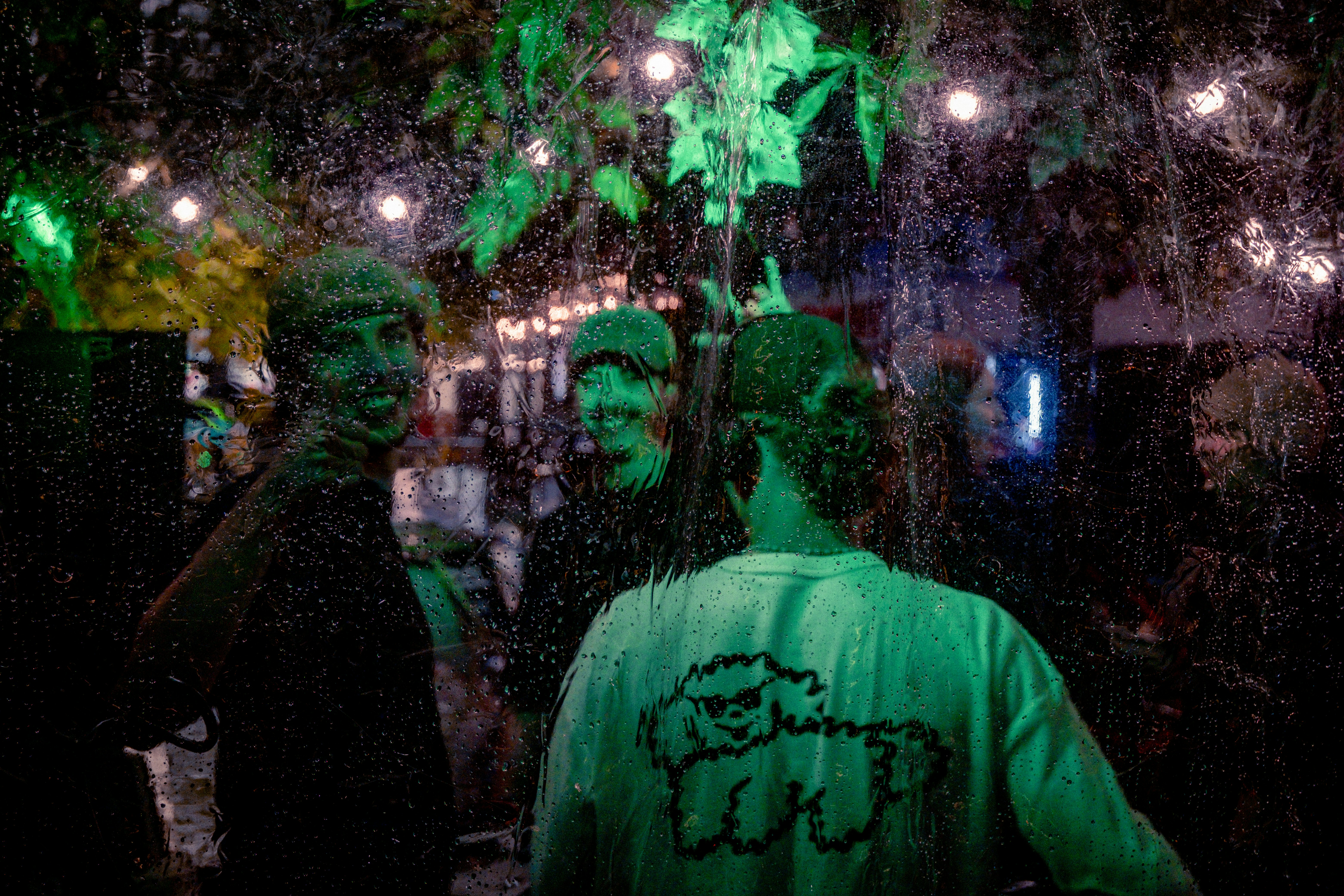 Nightlife Crowd Through Rainy Window Reflections