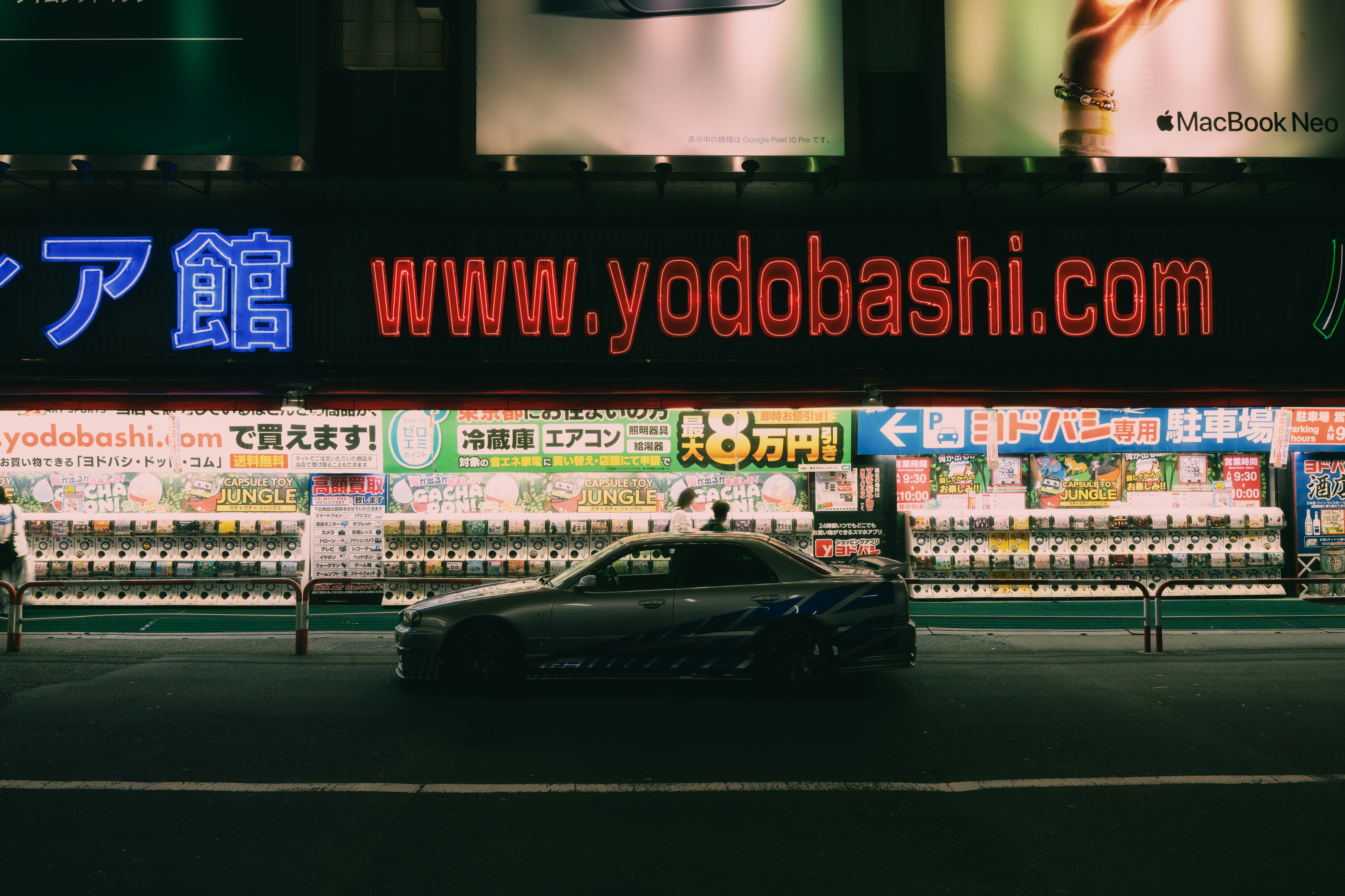 Neon Signage Over a Quiet Street: Midnight Taxi Almost Hidden Beneath Glow