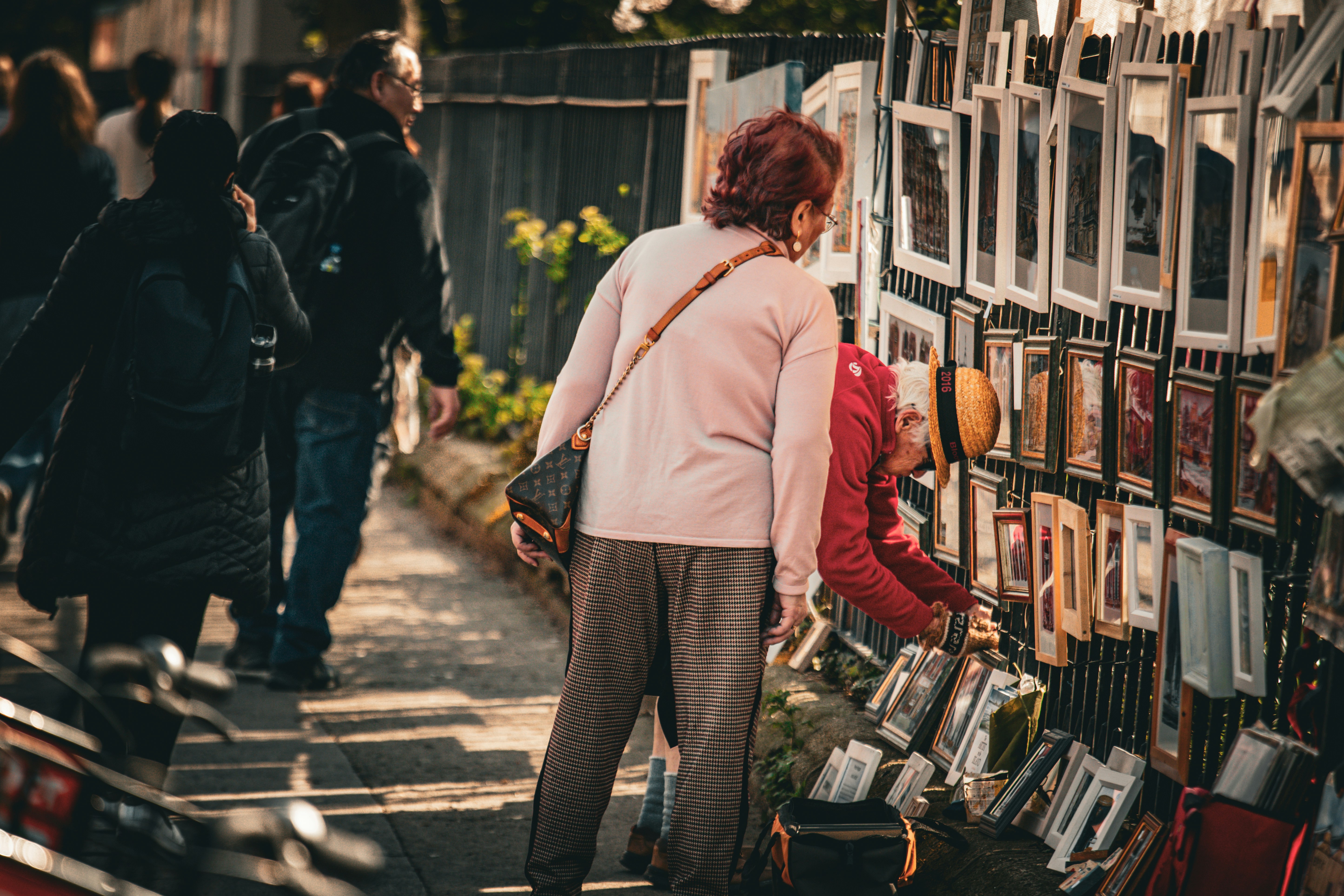 Colorful Street Gallery: An Elderly Visitor Browses Framed Moments