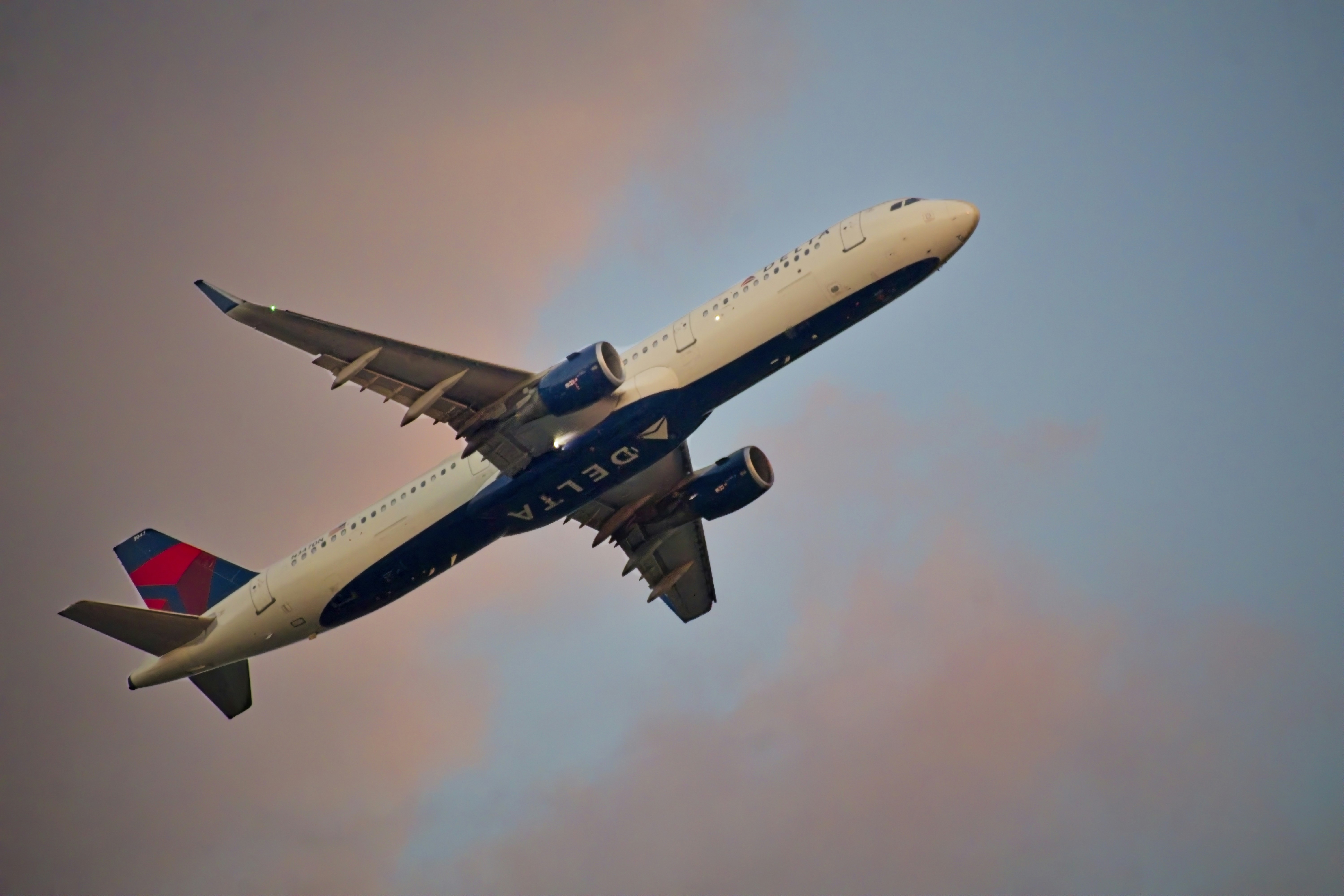 Airliner in ascent under soft clouds