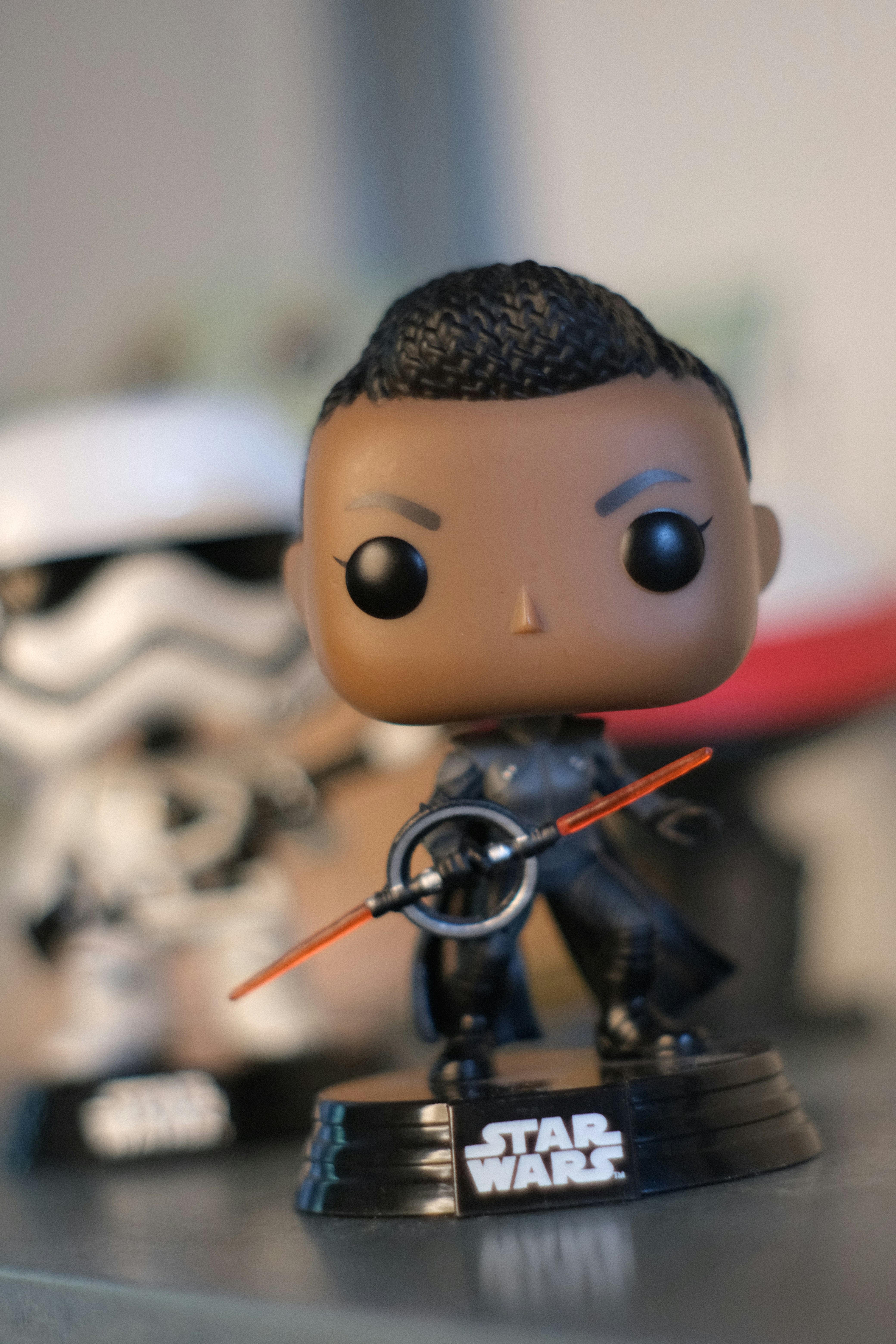 Mini Jedi in Focus: The Black-Suited Figure with Red Lightsaber Stands Center Stage