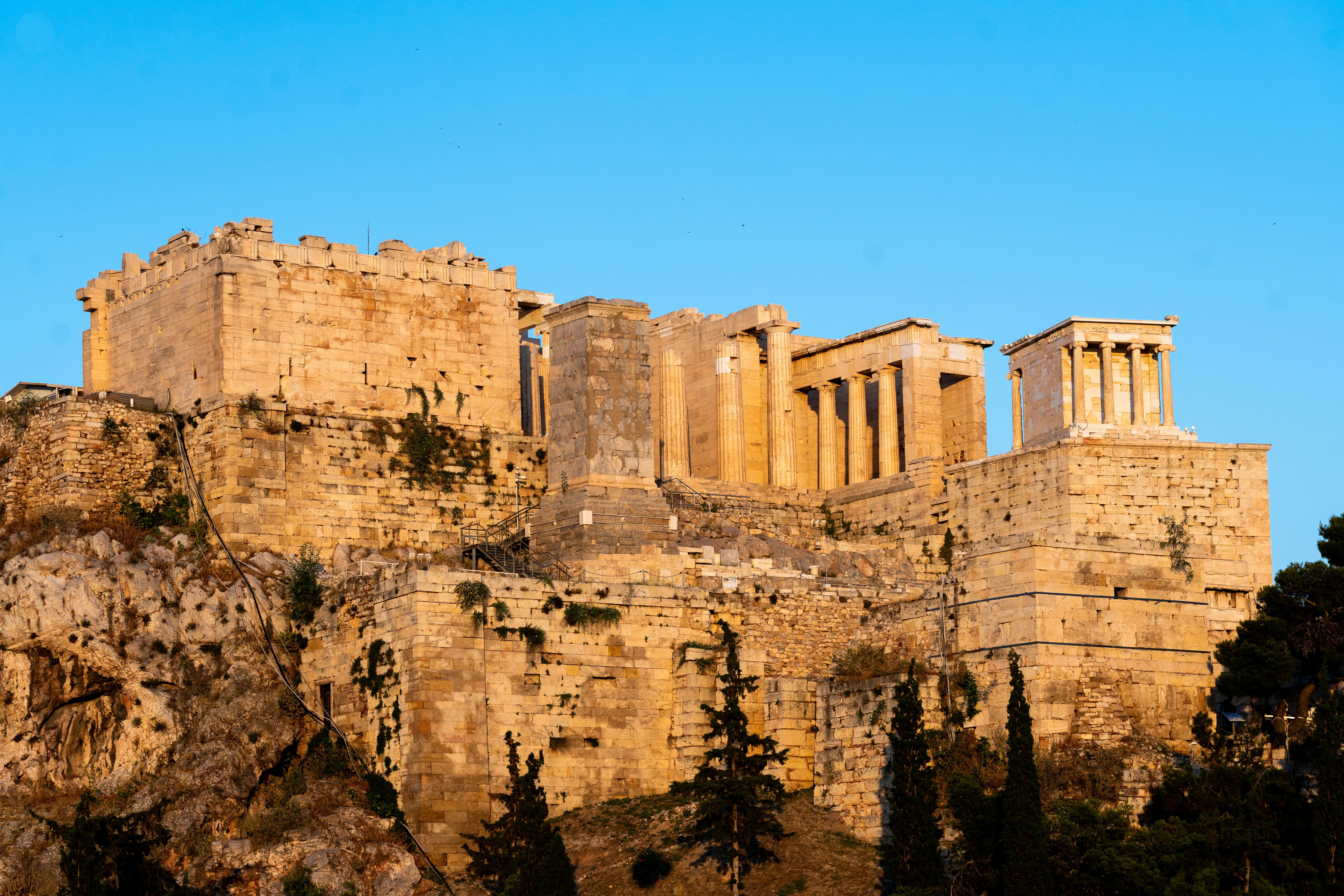 The ancient acropolis of athens under a clear blue sky.