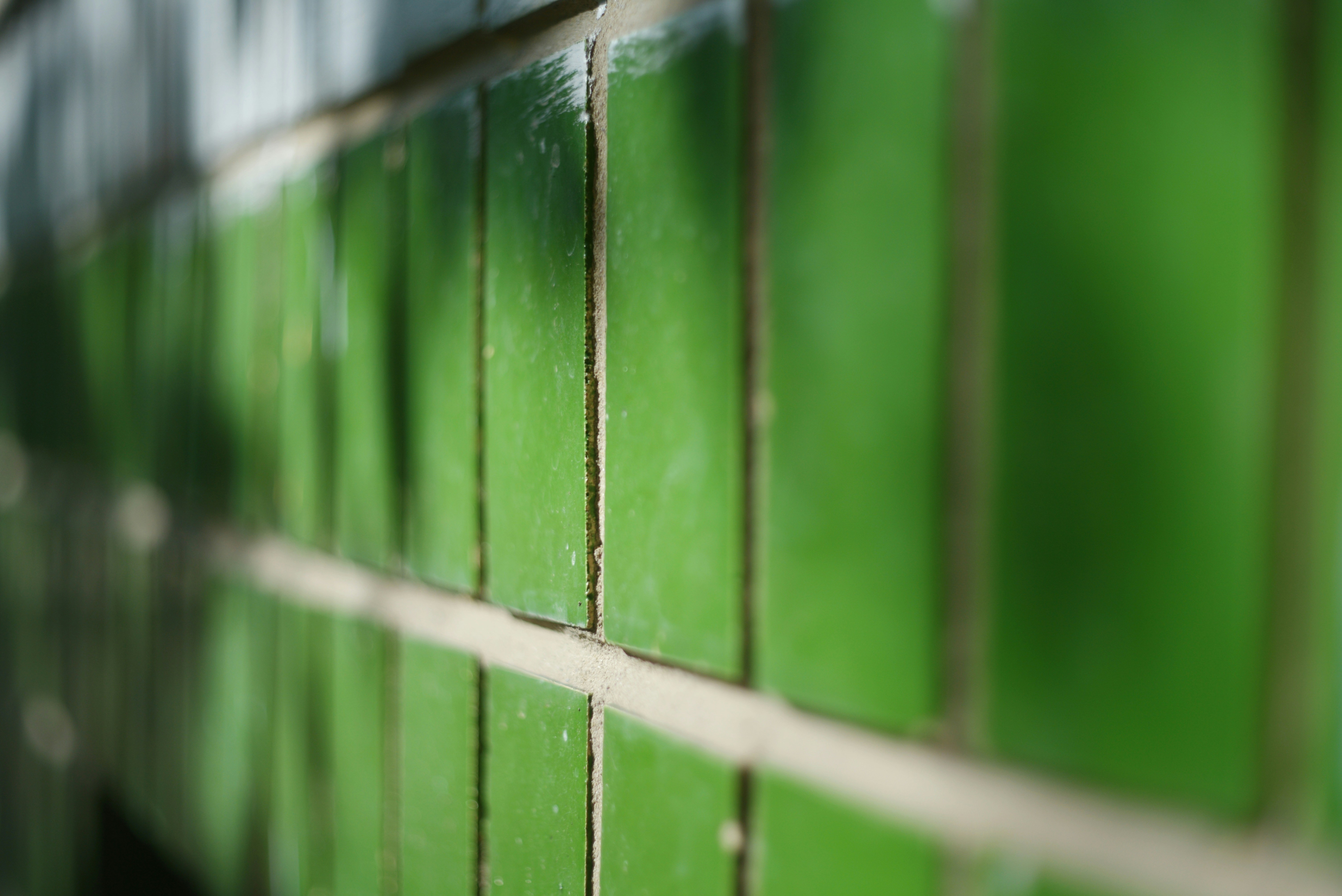 Emerald Wall: A Close-Up of Painted Tiles Dimming into Depth