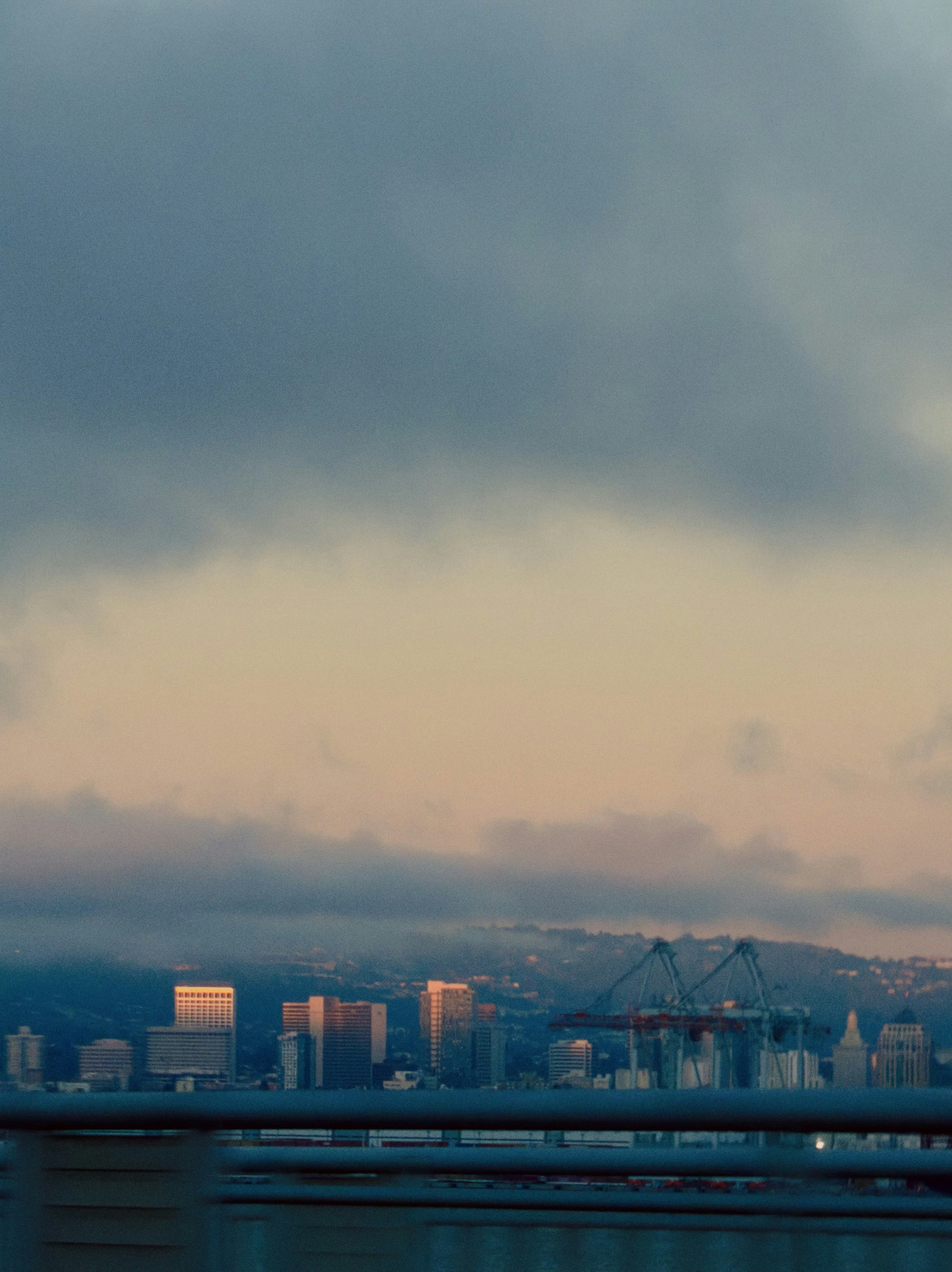 Sunrise over a city skyline, buildings reflecting golden light.