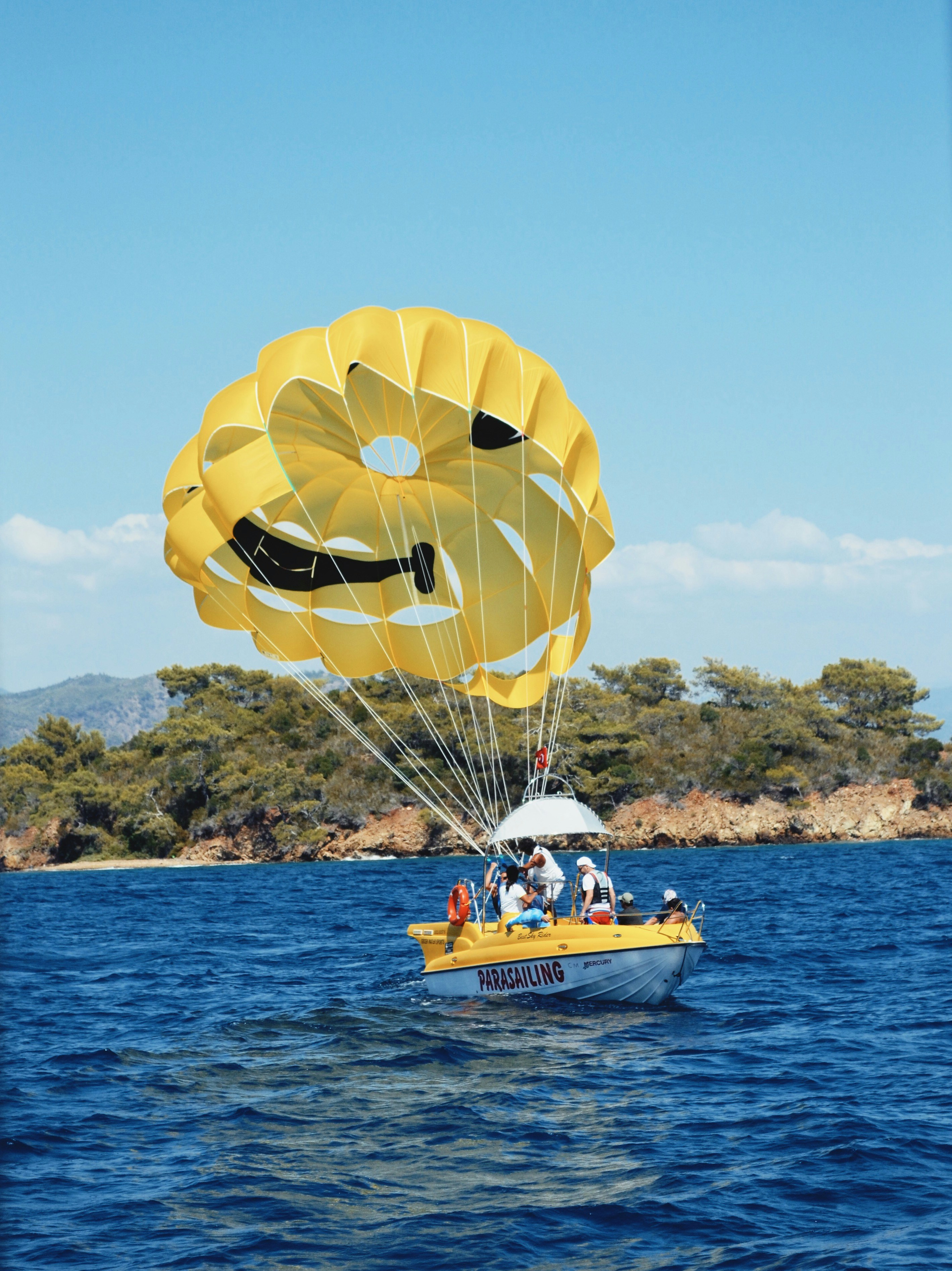 Parasailing in Calm Seas: A Sunny Descent Beneath a Yellow Paraglider