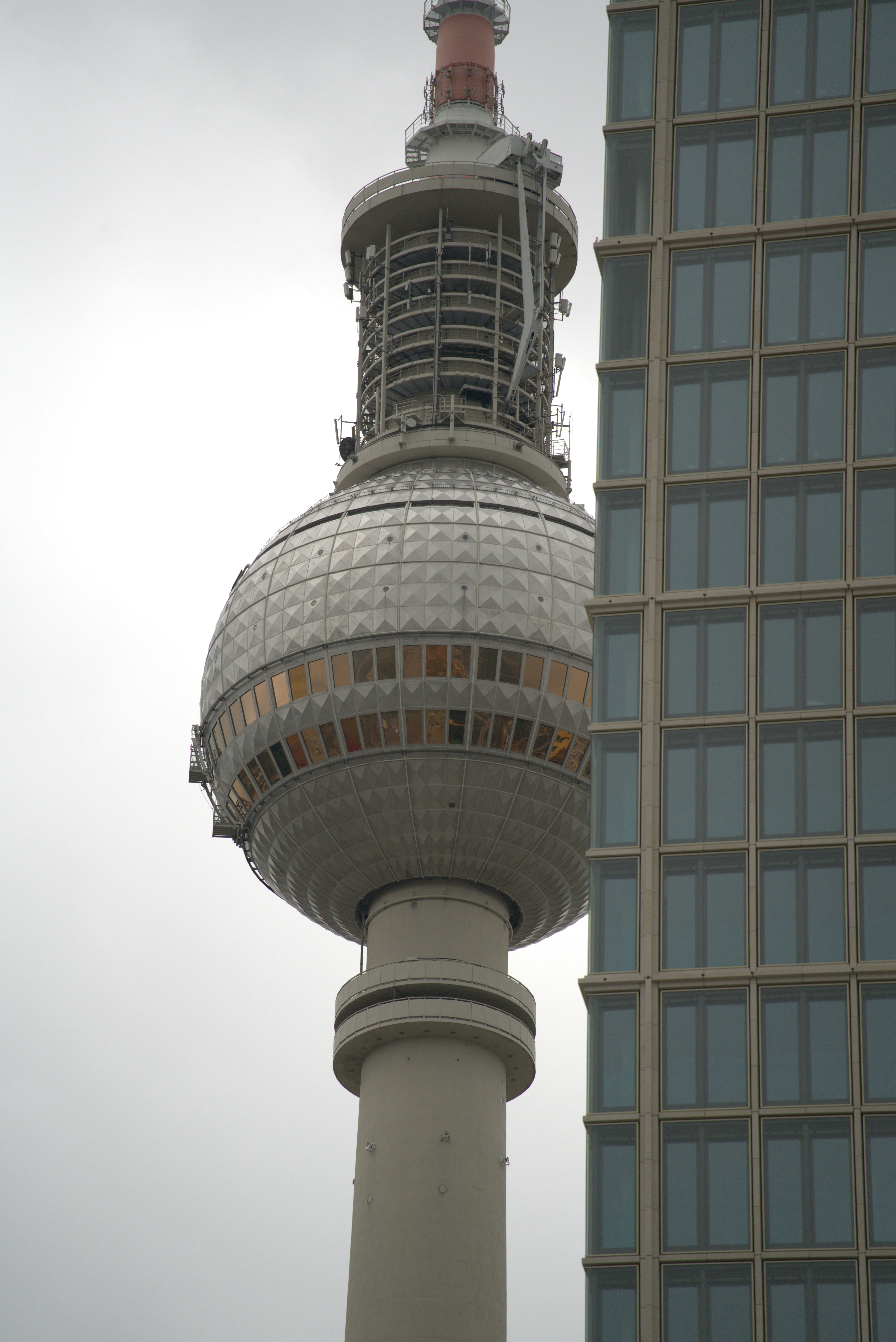 Distant Beacon: The Turbulent Sphere beside a Glass Facade