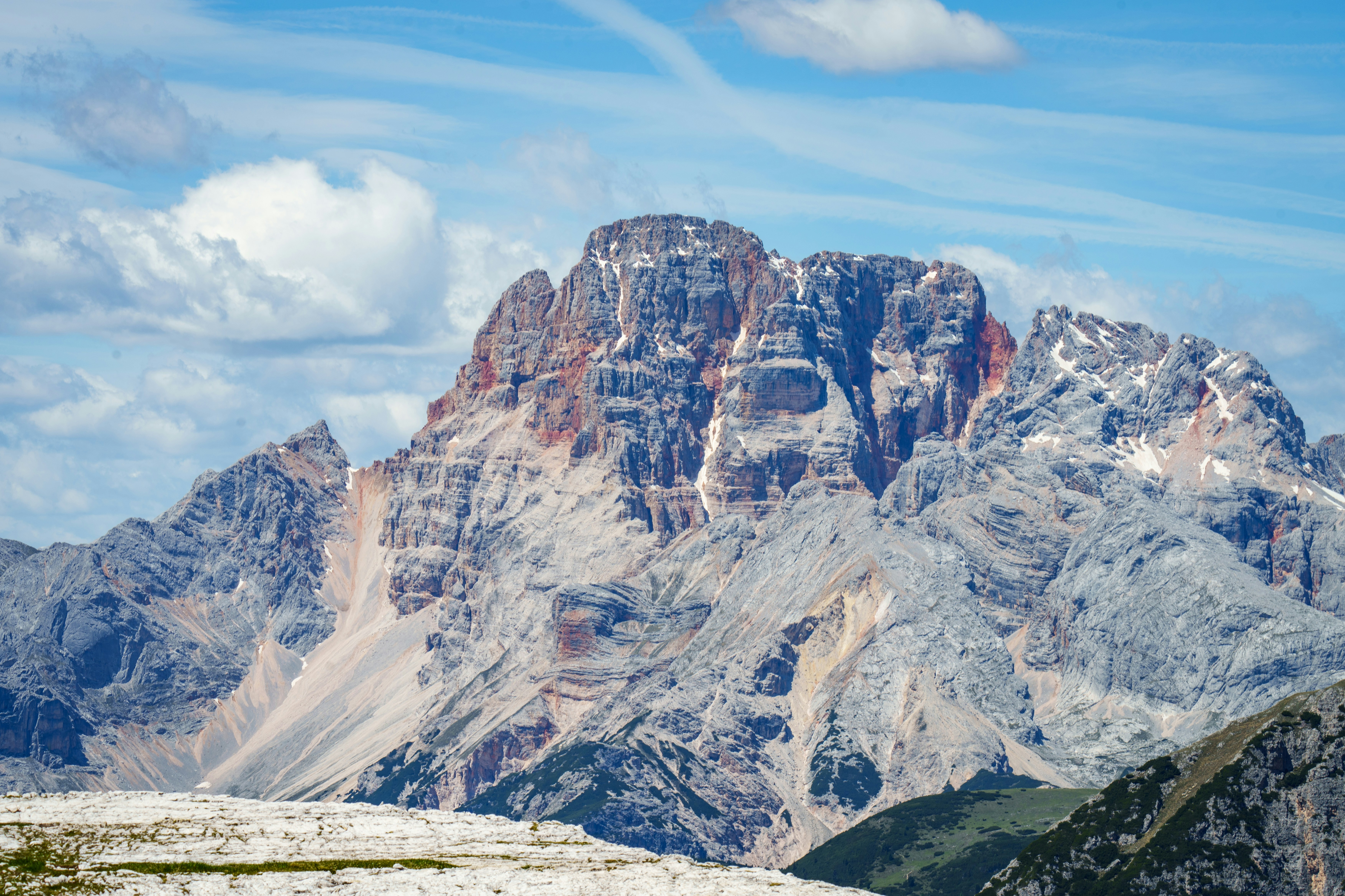 Storm-touched Pyramids: A rugged Alpine Facade Beneath Wide Skies
