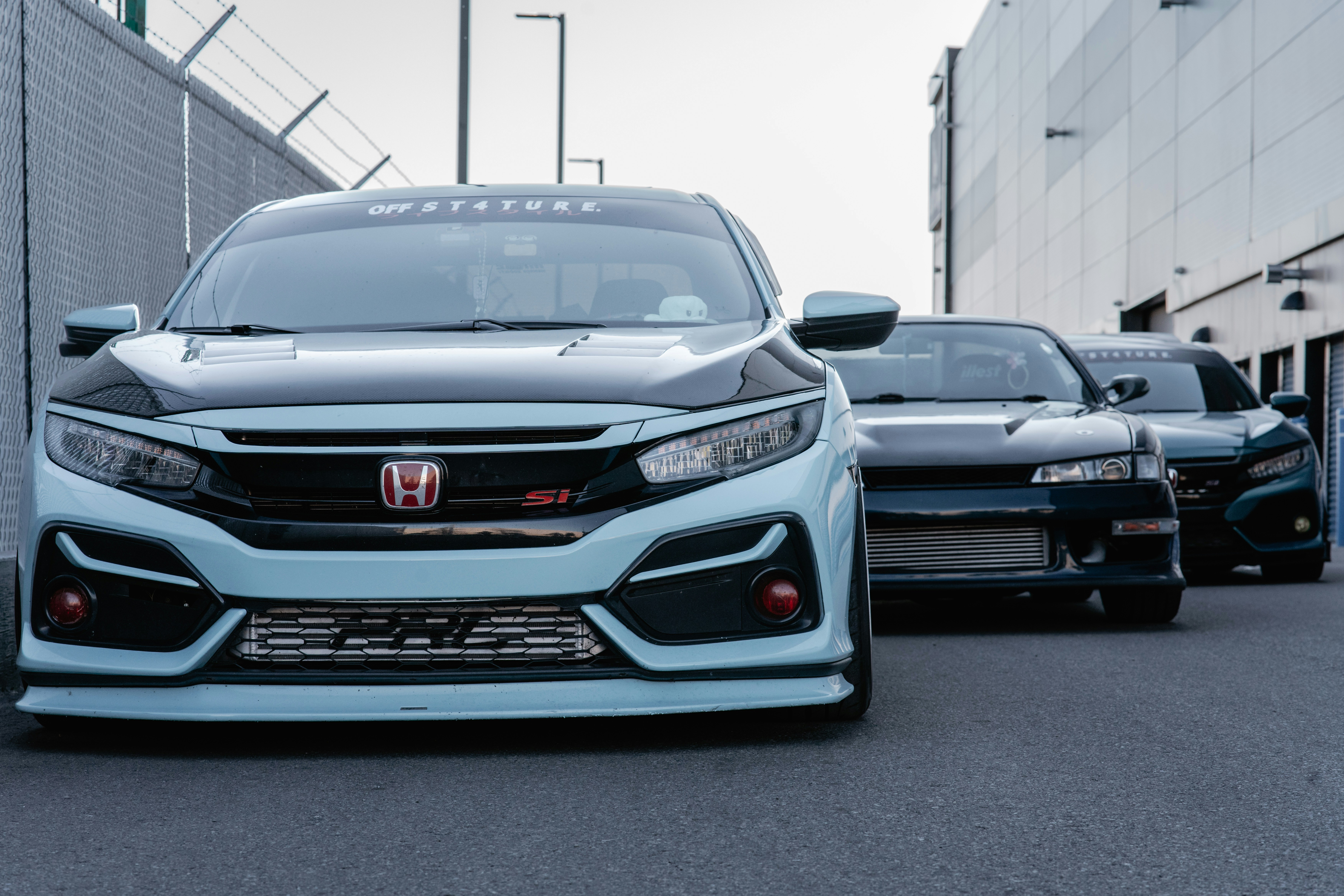 Low-Angle Lead Car: A Row of Sporty Sedans at the Factory Gate