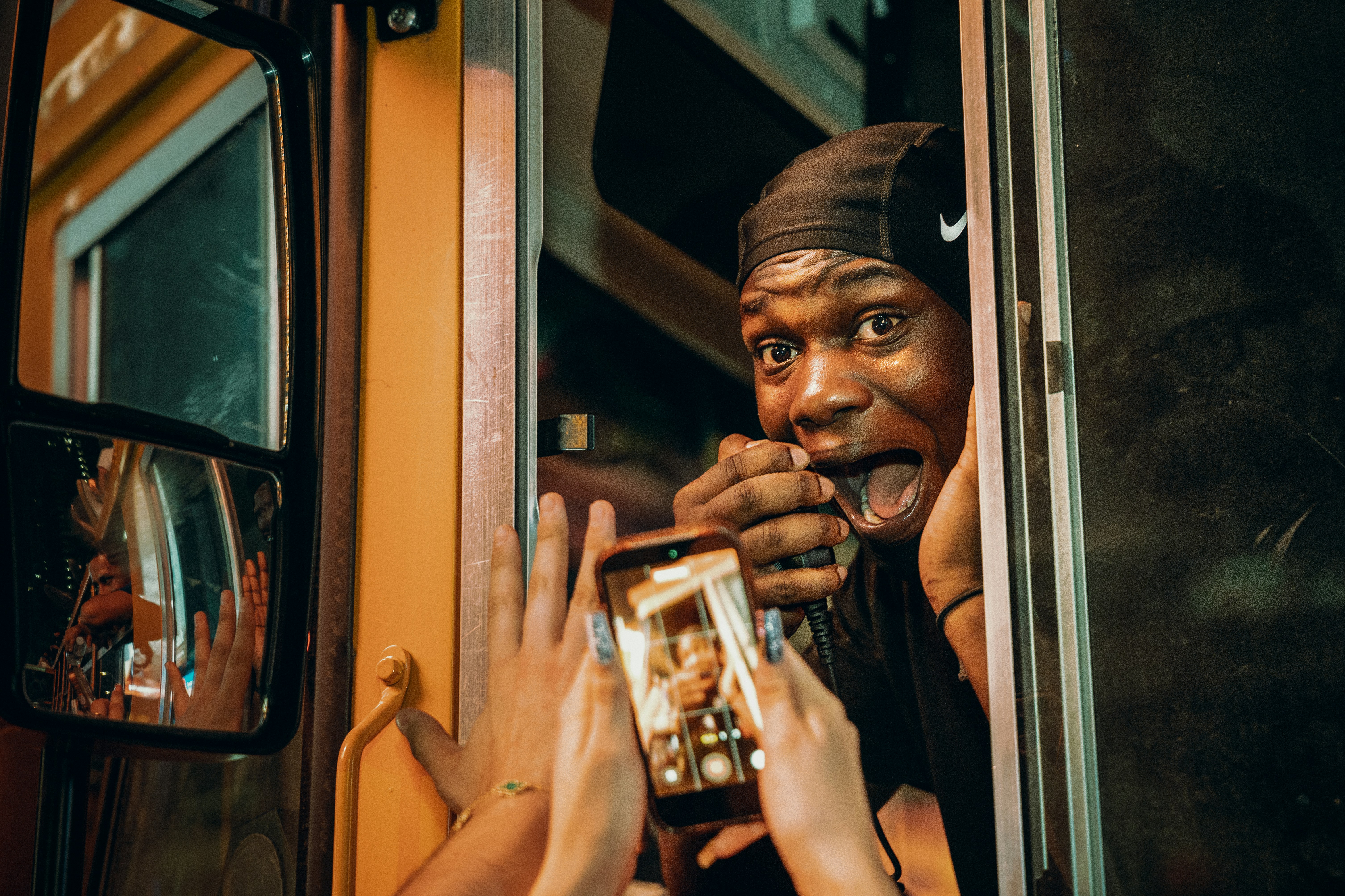 Joyful surprise from a bus window as fans capture a candid moment