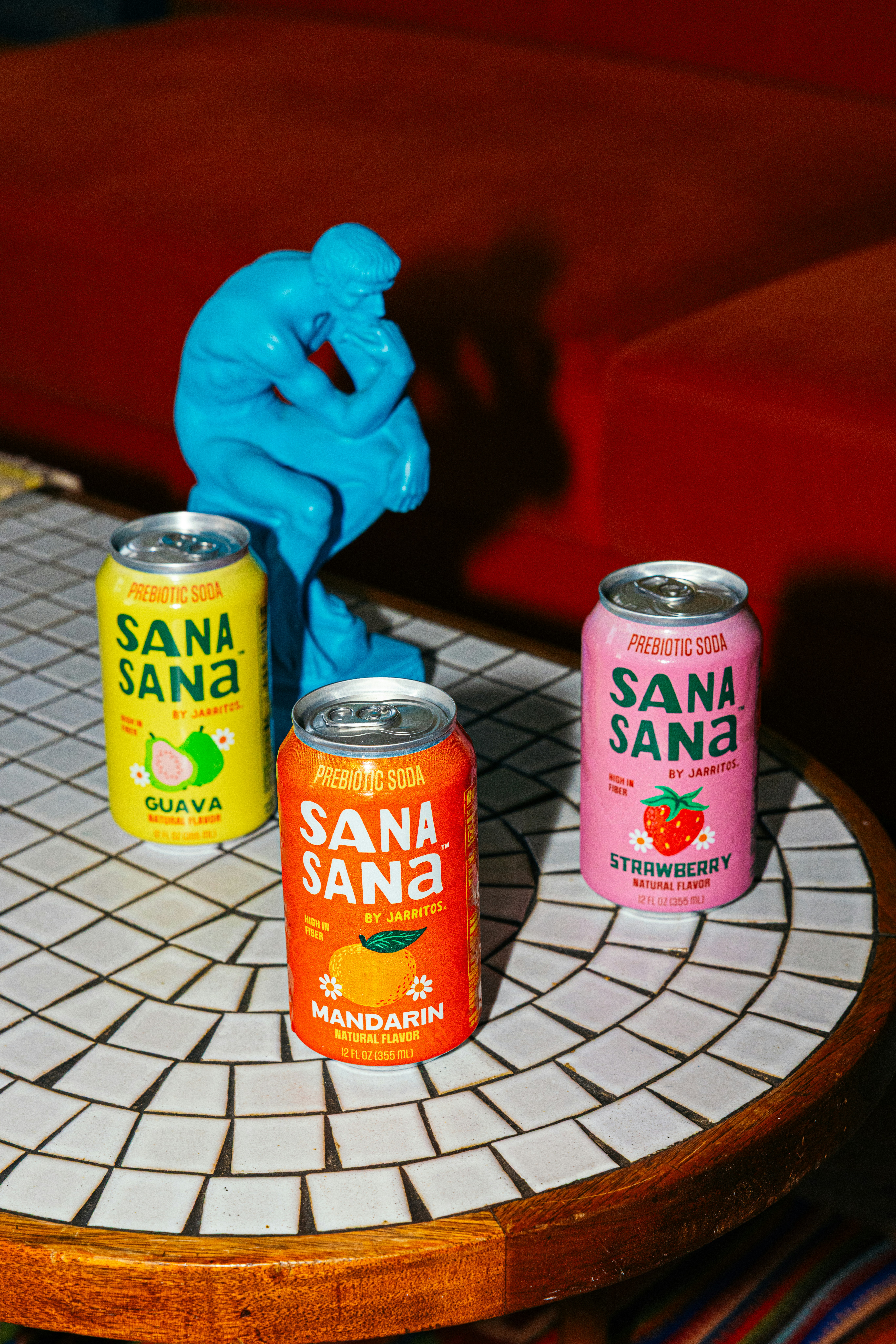 Blue statue guards a colorful soda circle on a tiled table