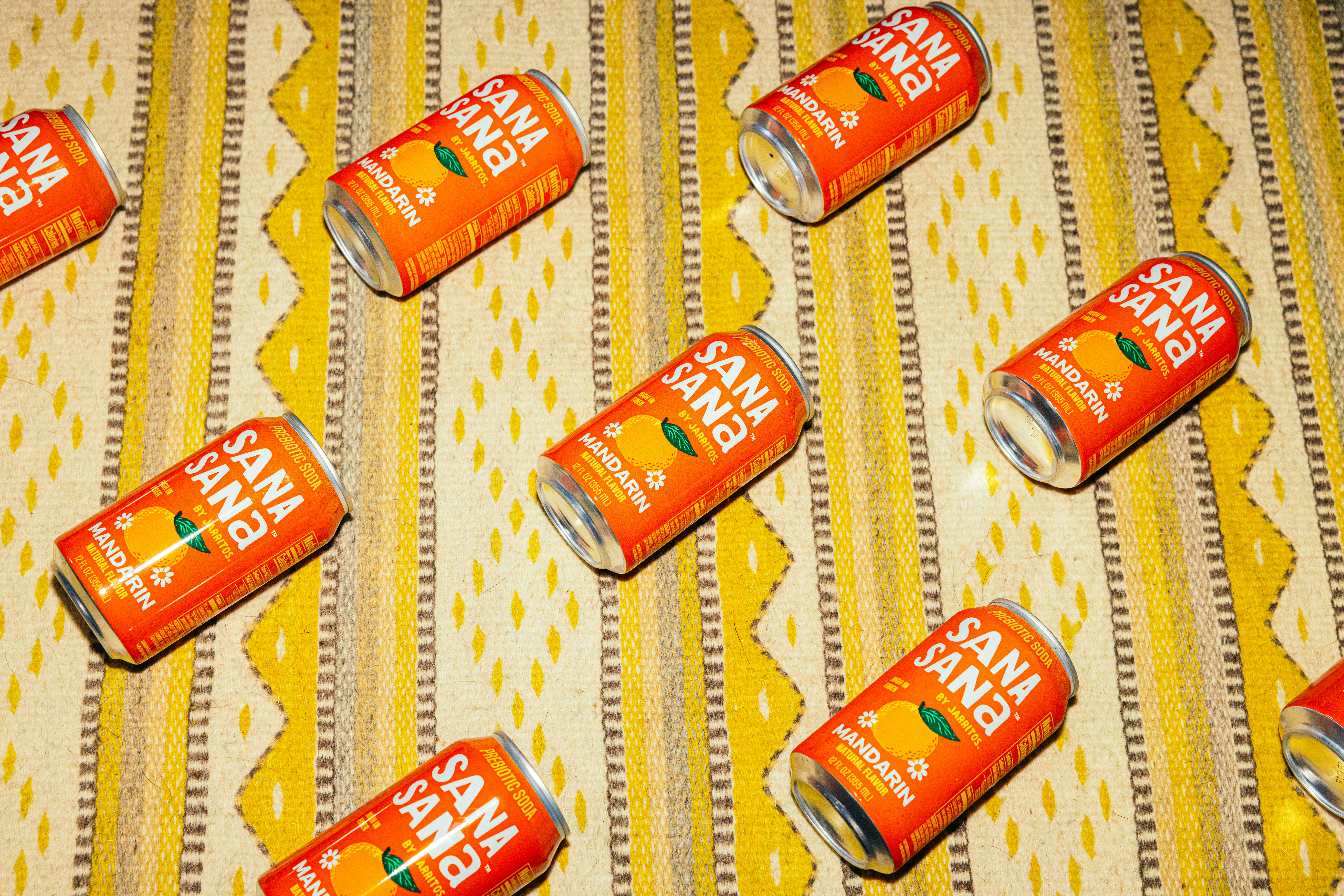 Candy Orange: a diagonal mosaic of San Sano cans on patterned fabric