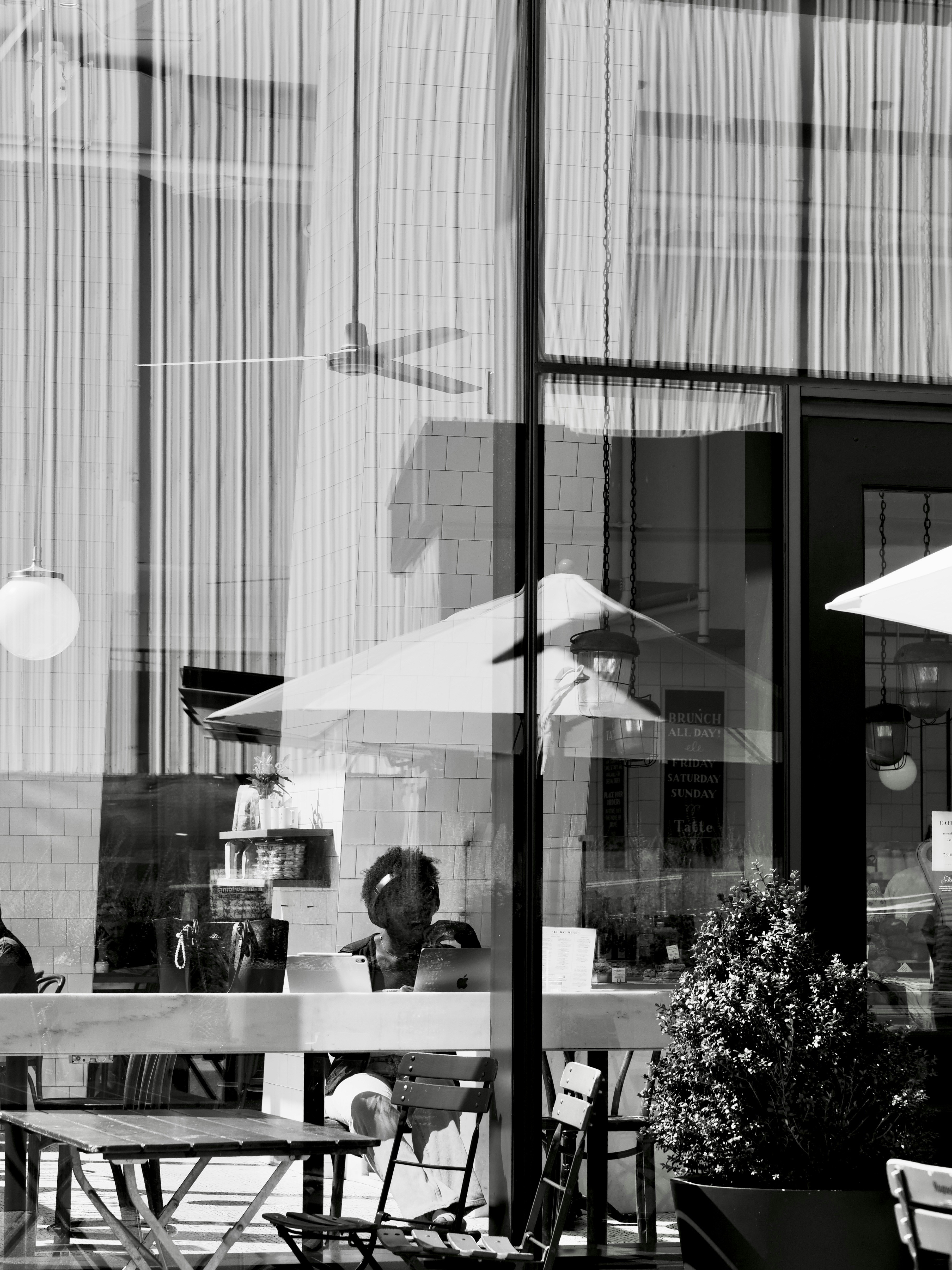 Glass and Shadow: A Quiet Café Moment Through a Street Window
