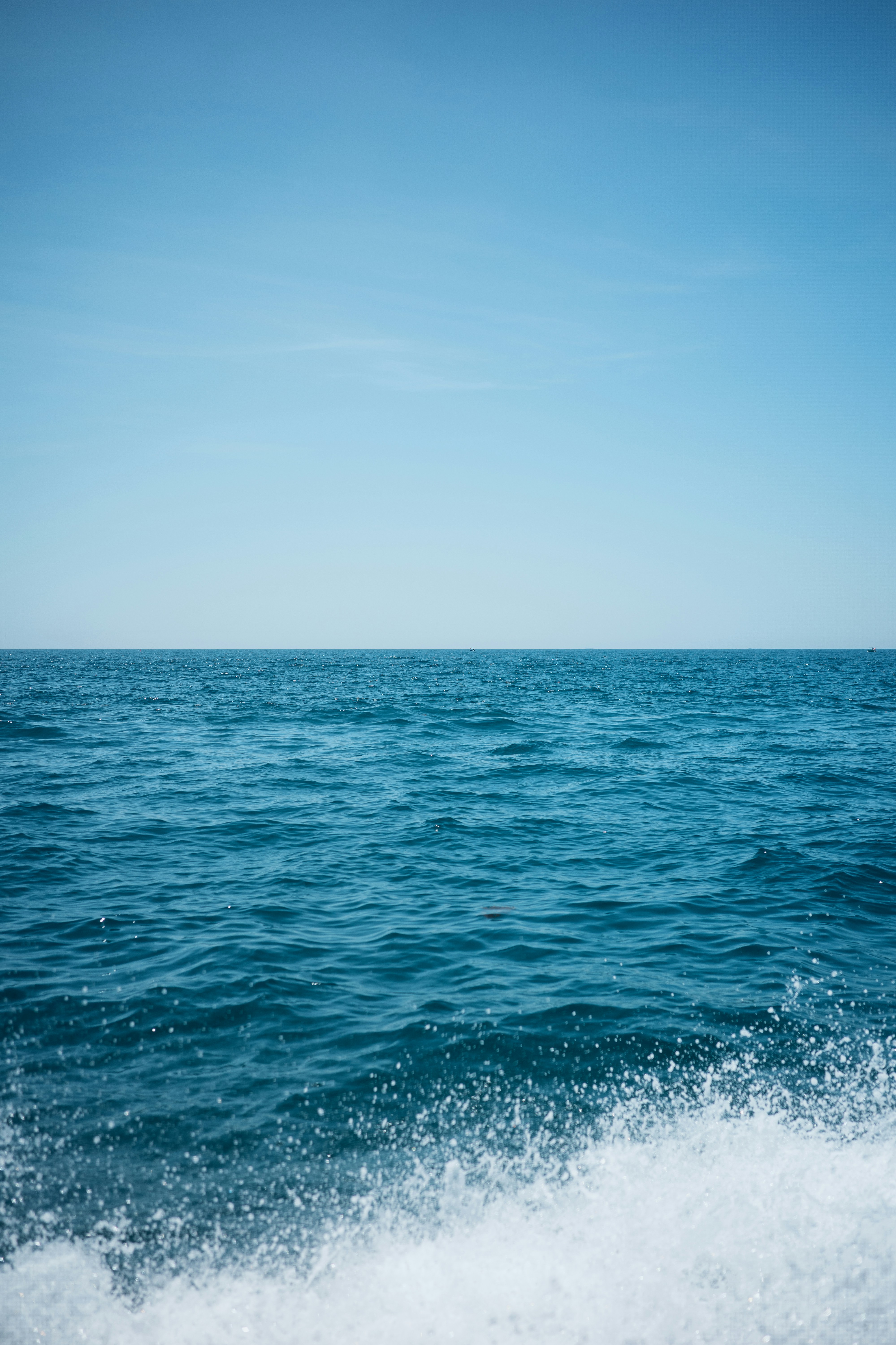 Blue ocean water with white splashes under a clear sky. photo – Free ...