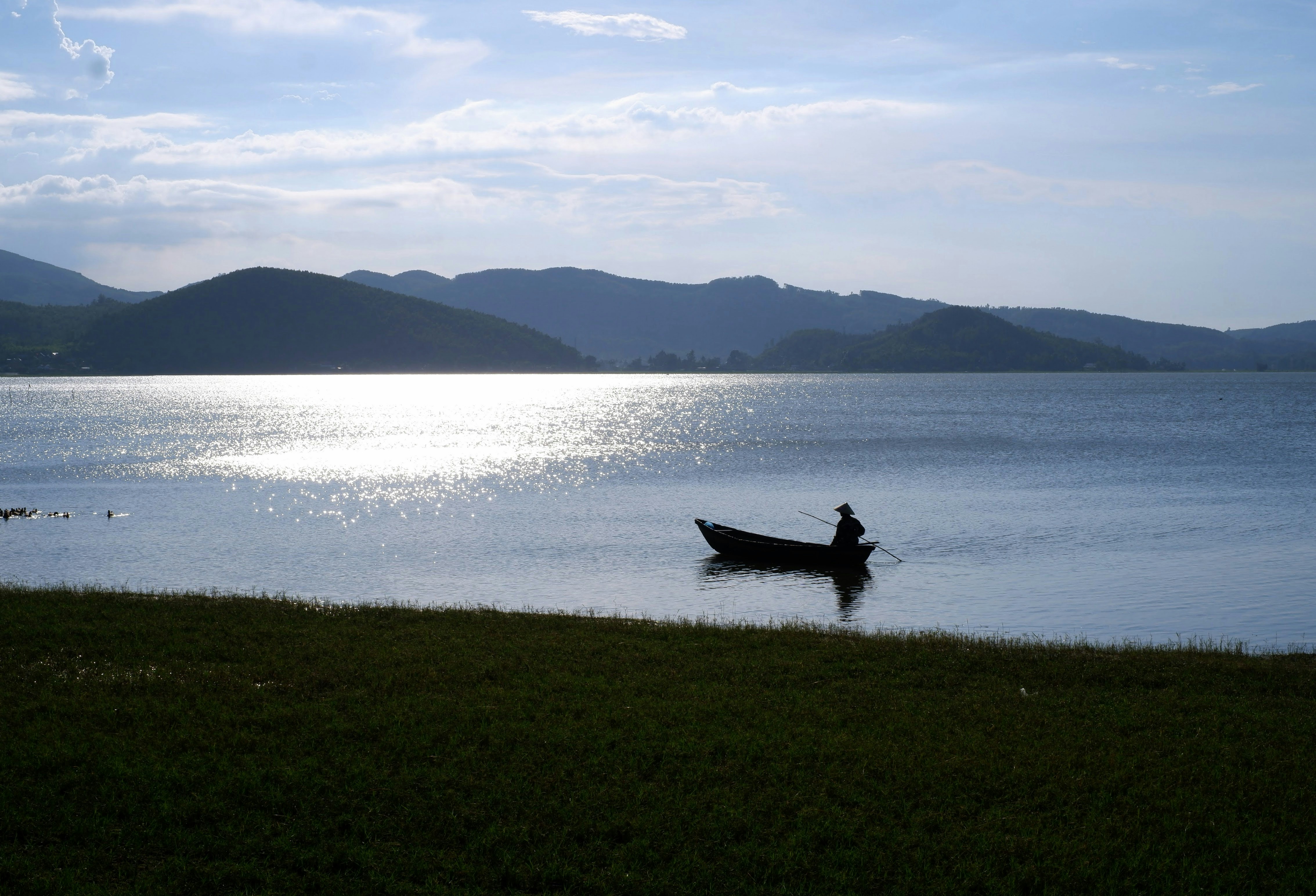 Silhouette of a Kayaker Against a Glimmering Lake