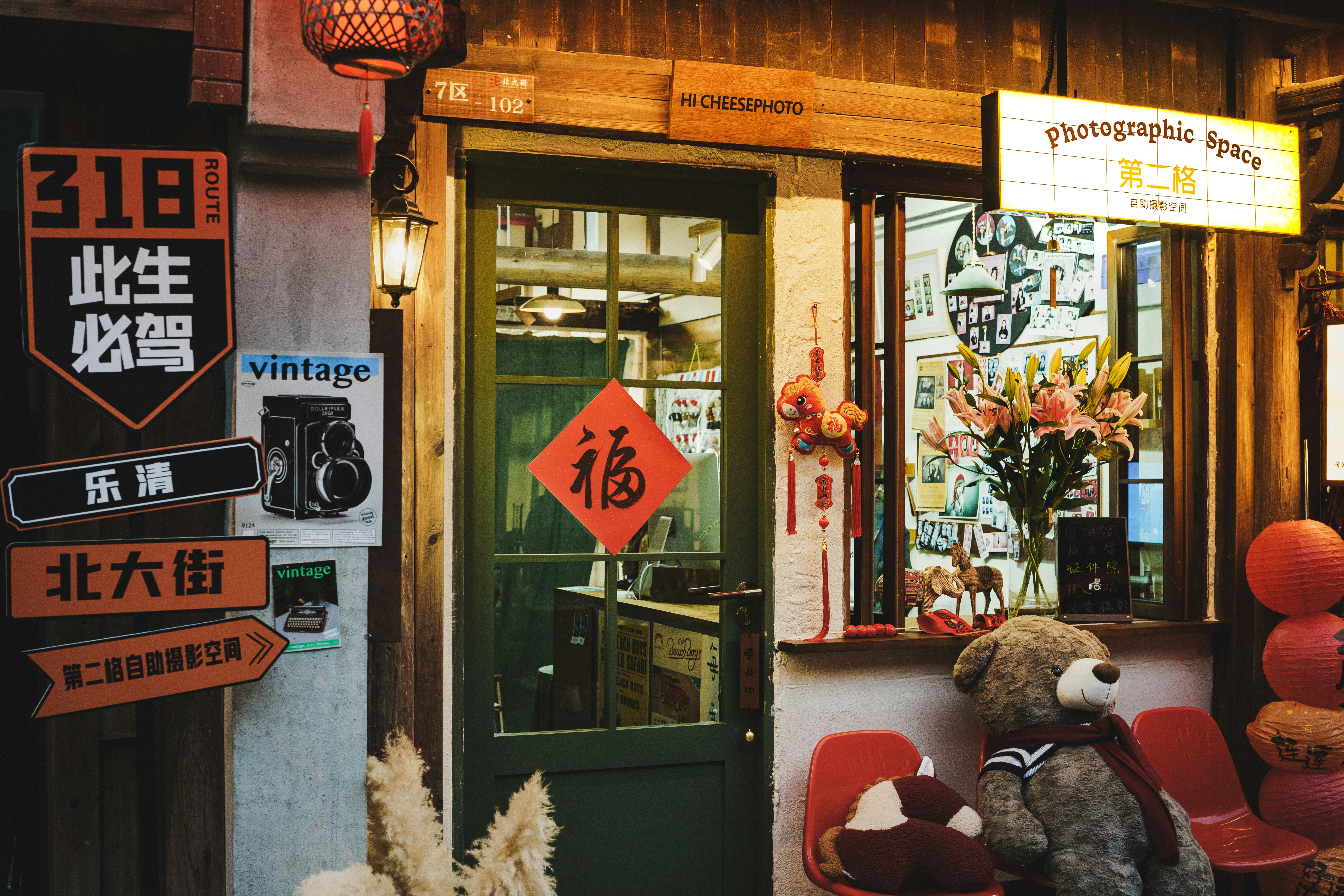 Lantern-lit Vintage Photo Shopfront with Plush Visitor
