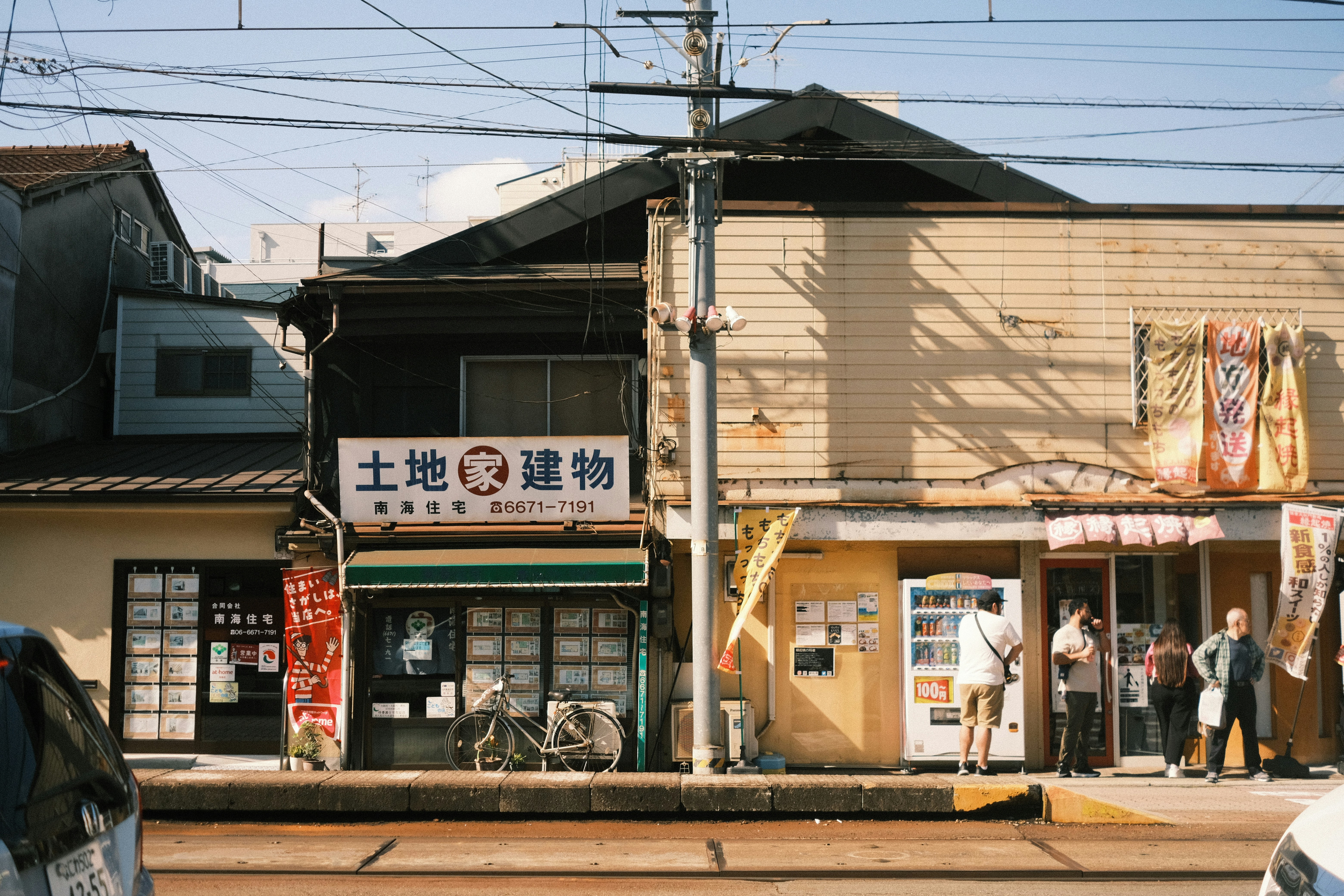 Storefront silhouettes: daily life on a sunlit Japanese street