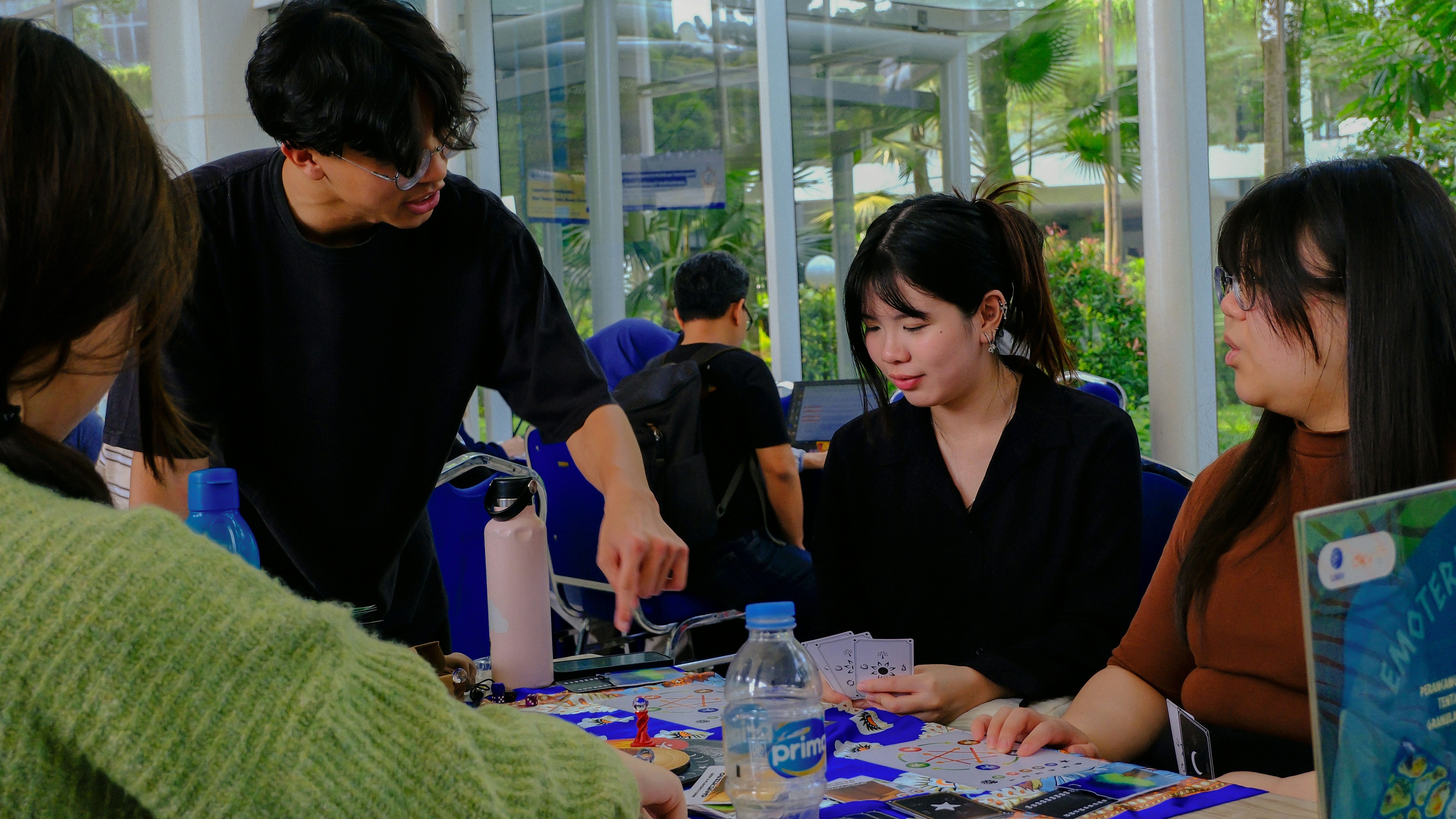 Man pointing at items on a table with friends.