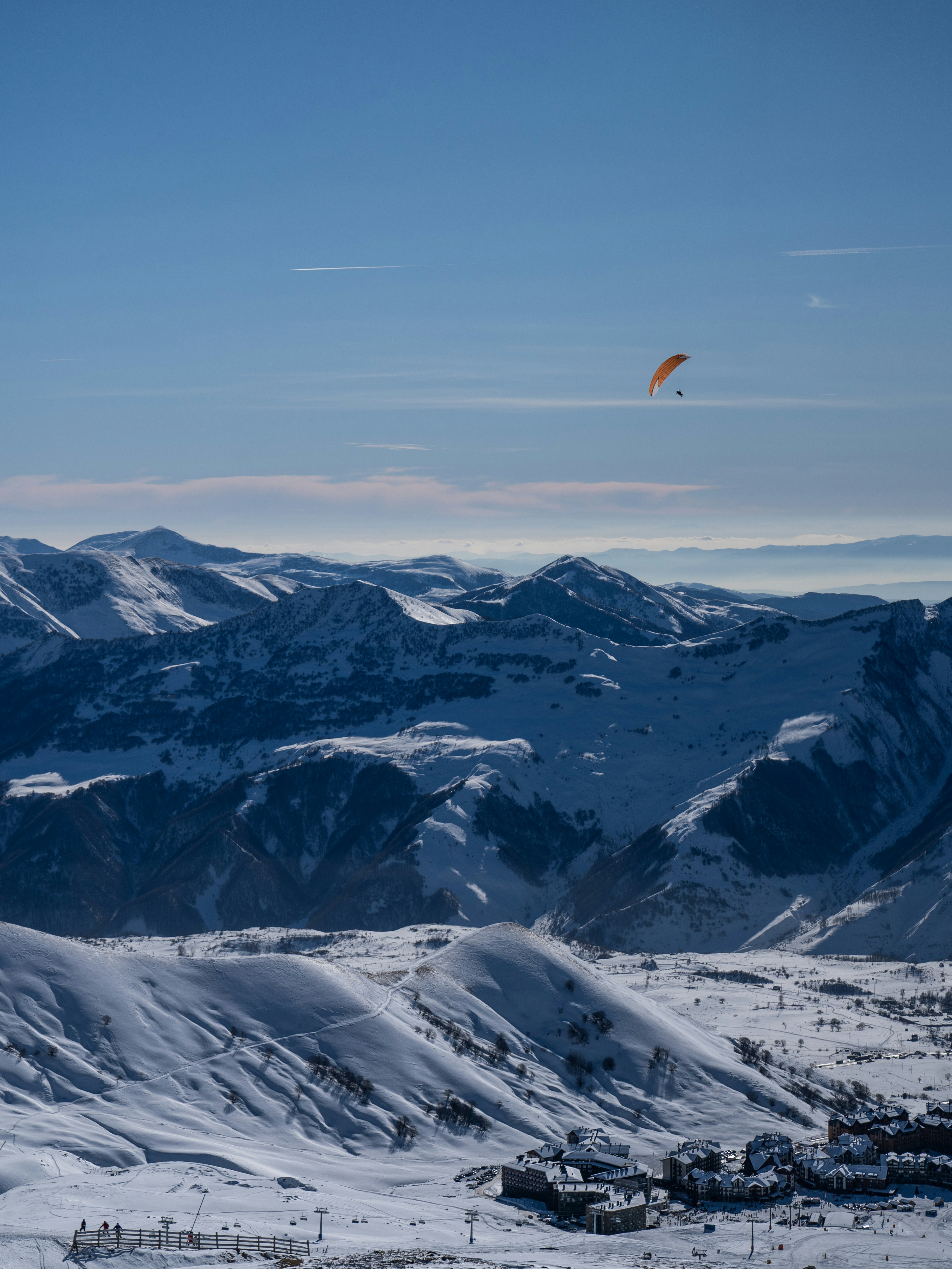 Blue Ridge of Snow: A lone paraglider Above Alpine Silence