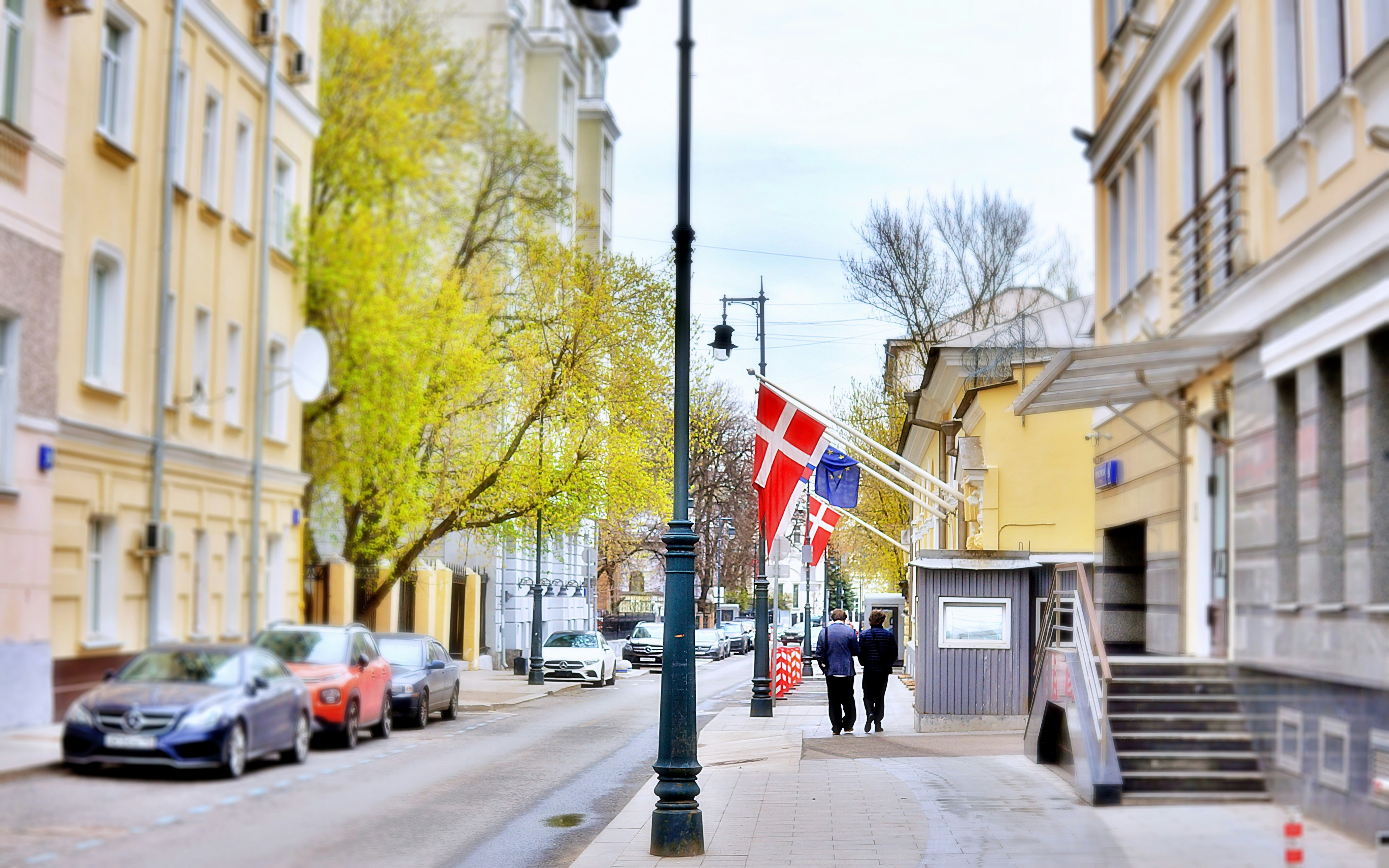 Flag-lined street converging toward a quiet bus stop