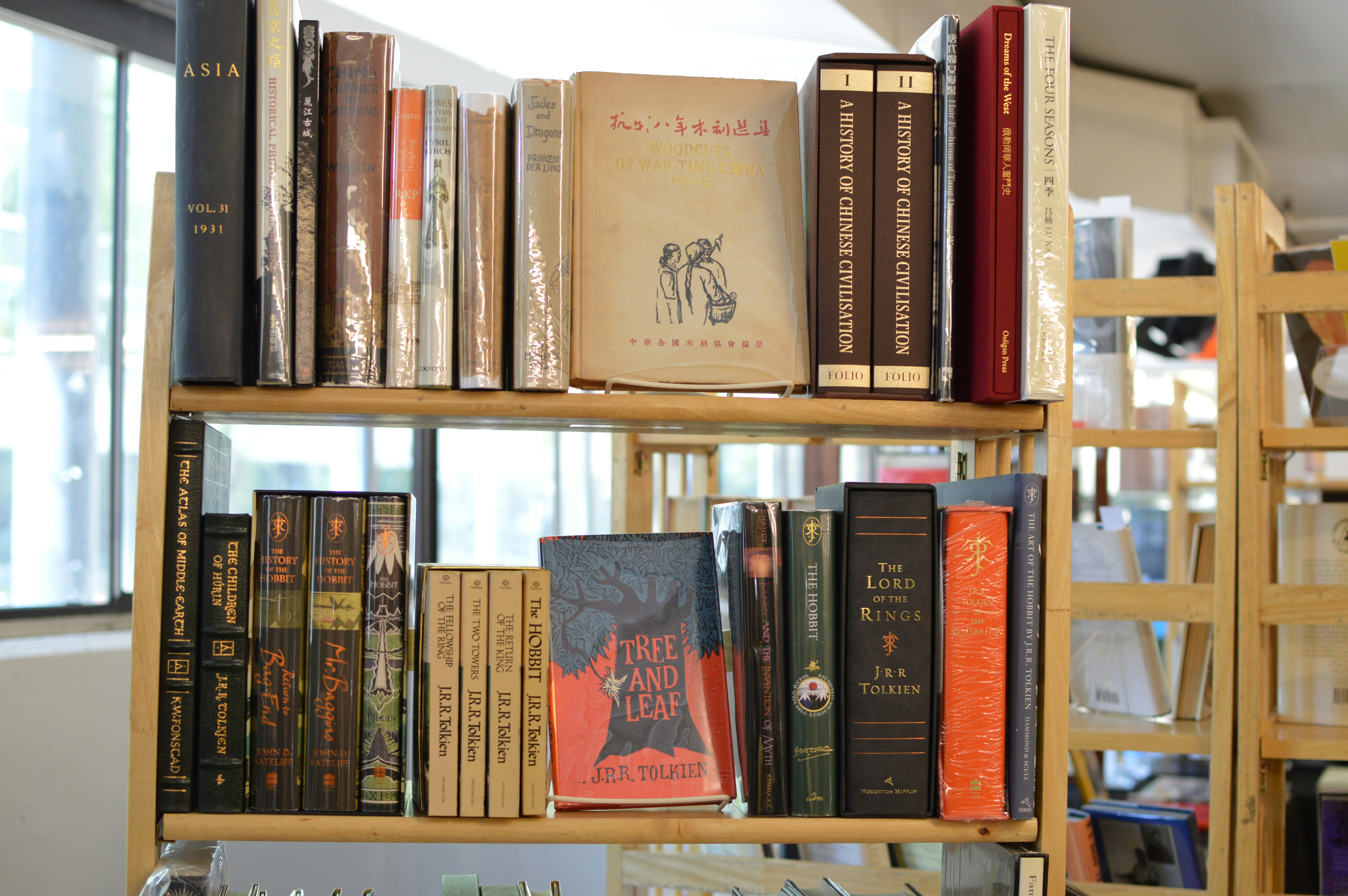 A wooden bookshelf filled with various old books.