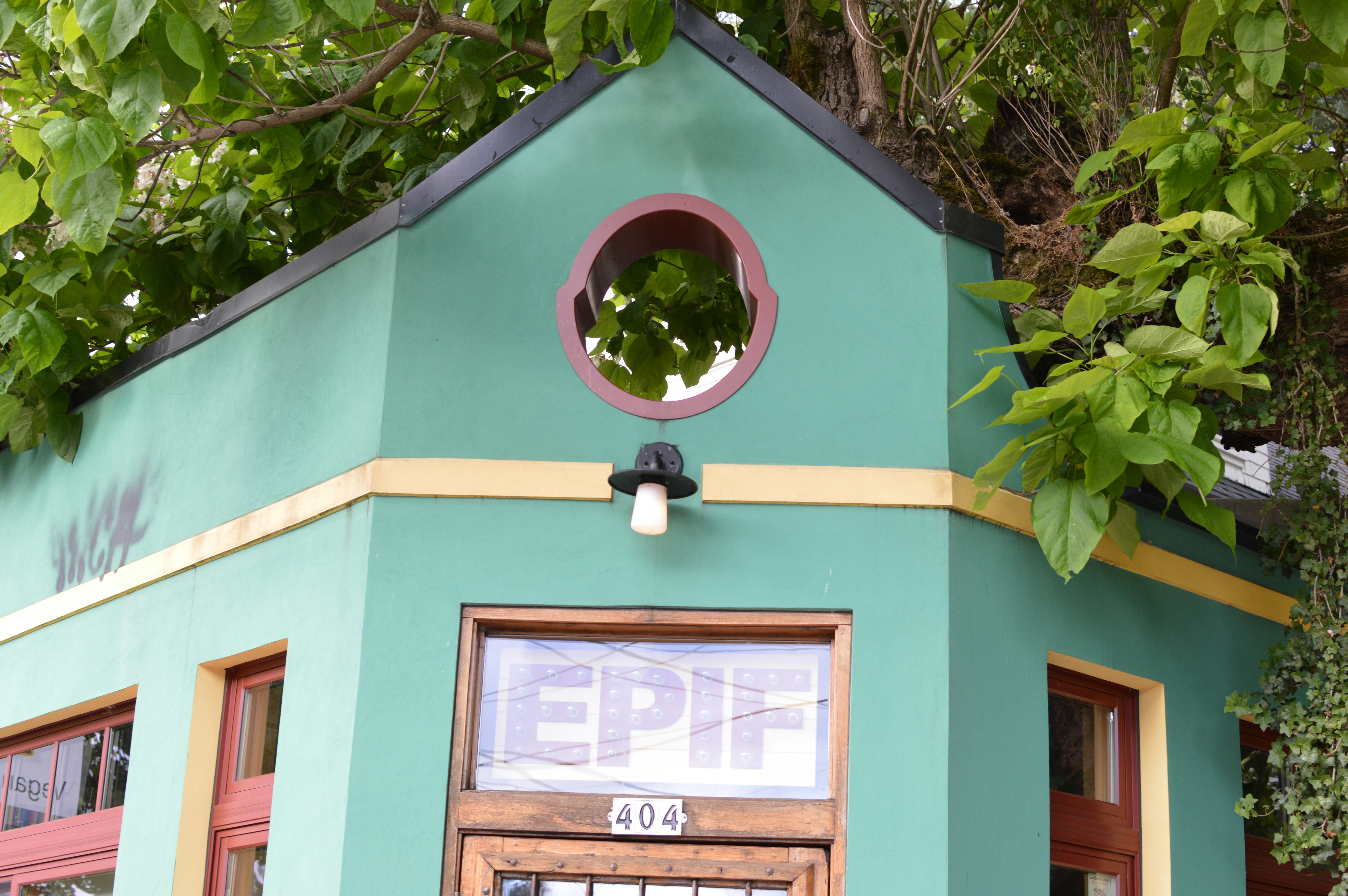 Teal Corner: Epif Café’s Circular Optic Light Framed by Green Facade