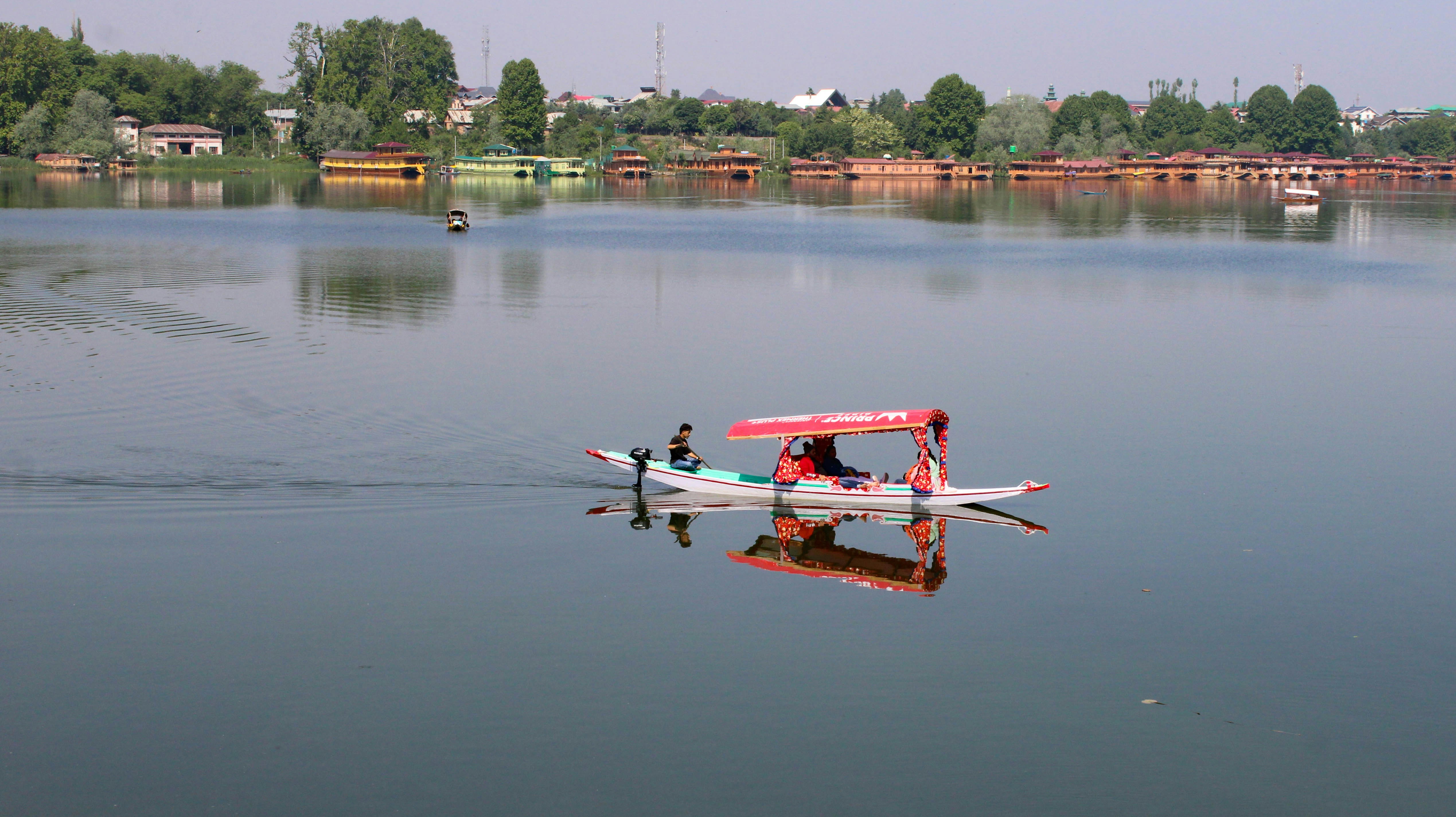 Boat Duo on a Glassy Lake with Distant Townline