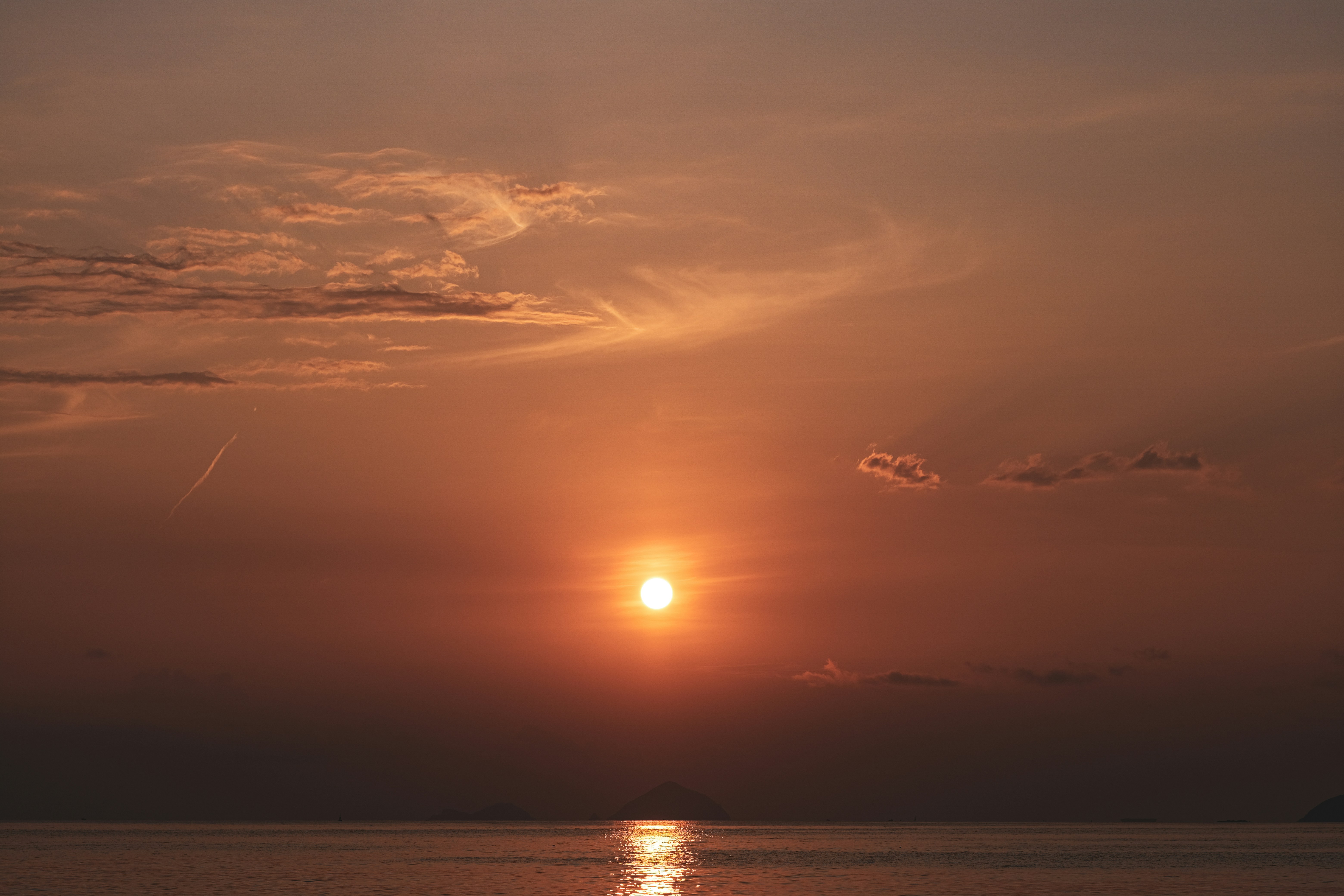 Horizon’s Quiet Burn: Sunset Reflections on a Calm Sea