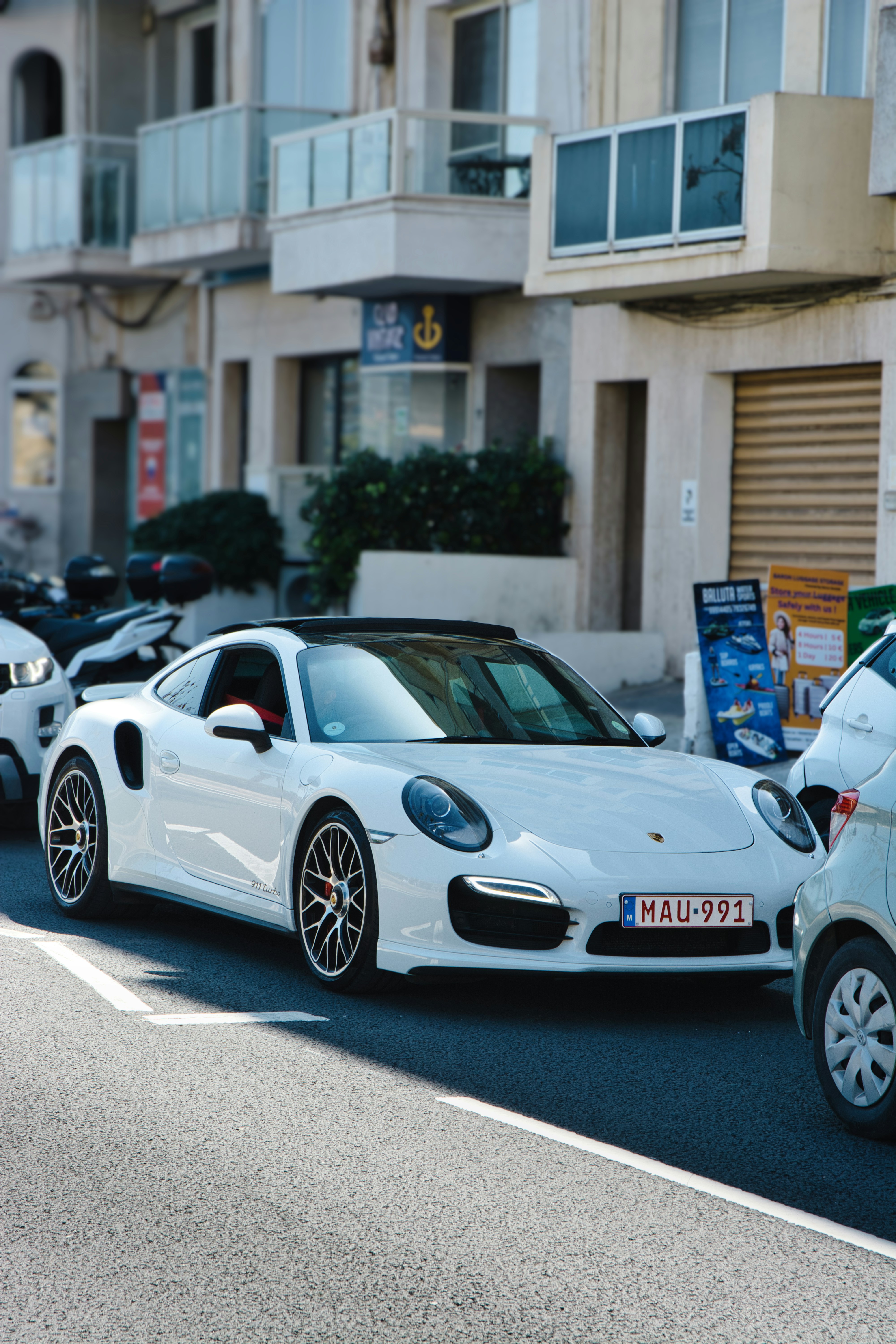 White Porsche on a sunlit Mediterranean Street