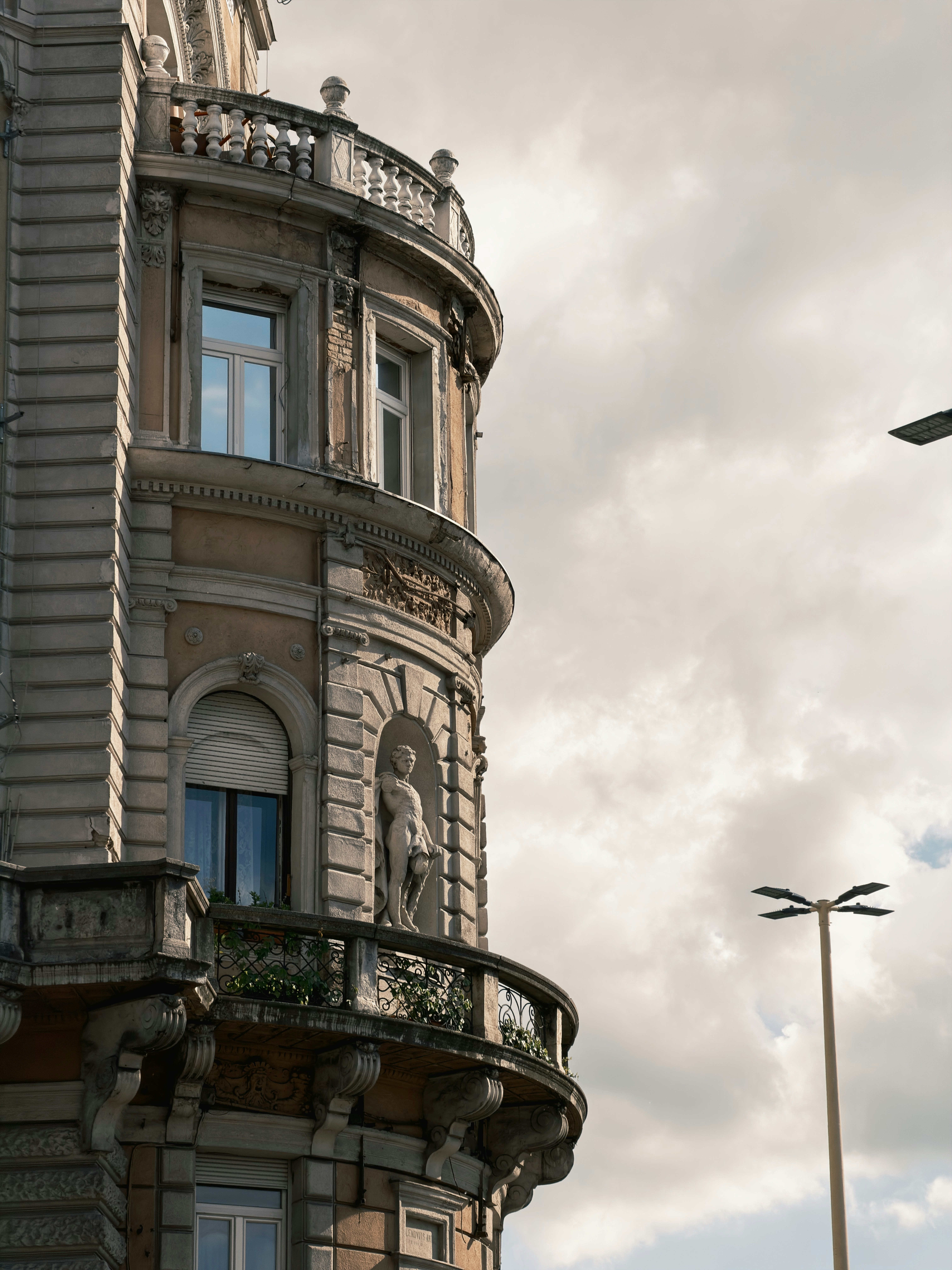 Historic Cornerstone: a curved façade with sculpted figures against a dramatic sky