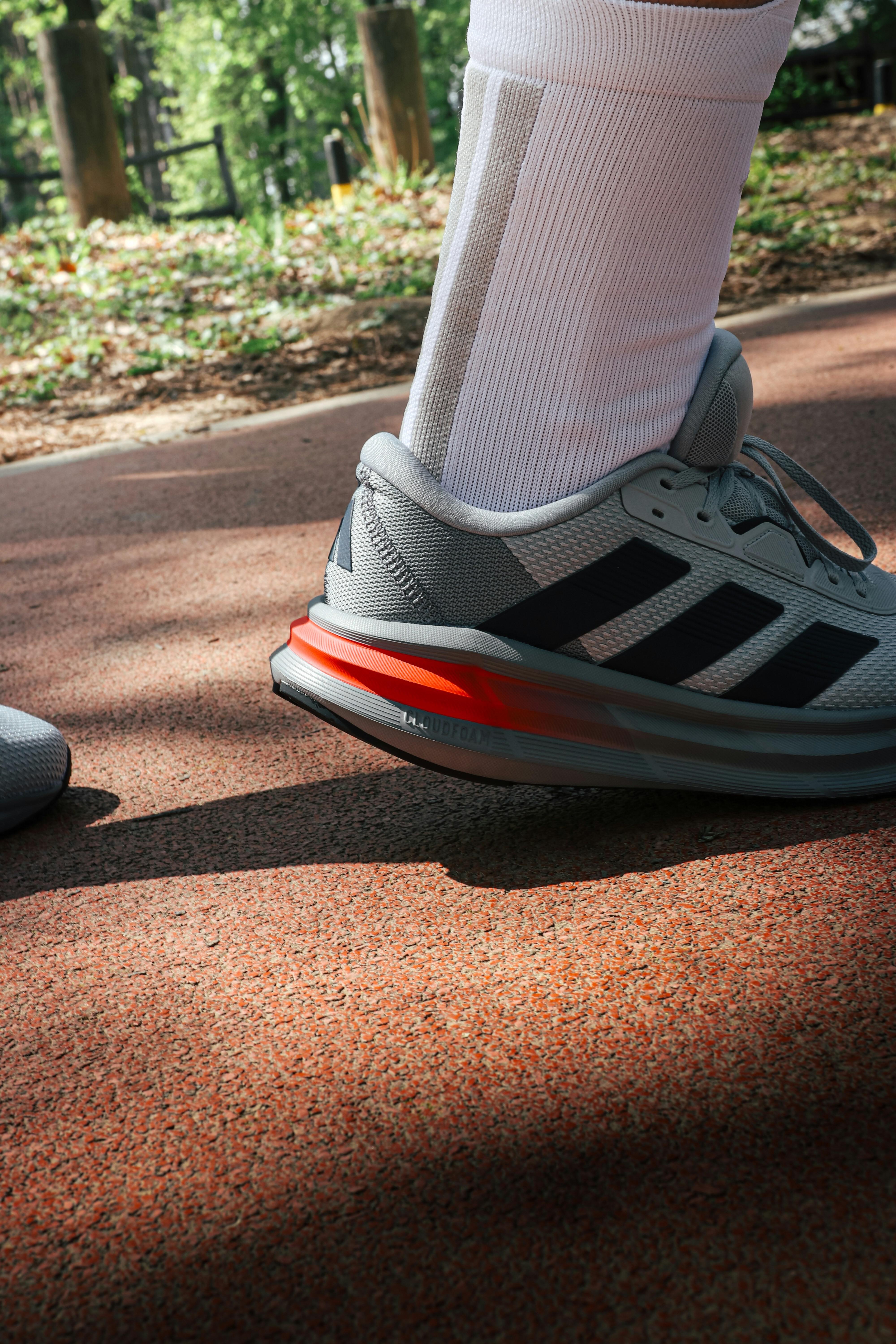 Stride in Focus: A Runner's Sole on a Park Track