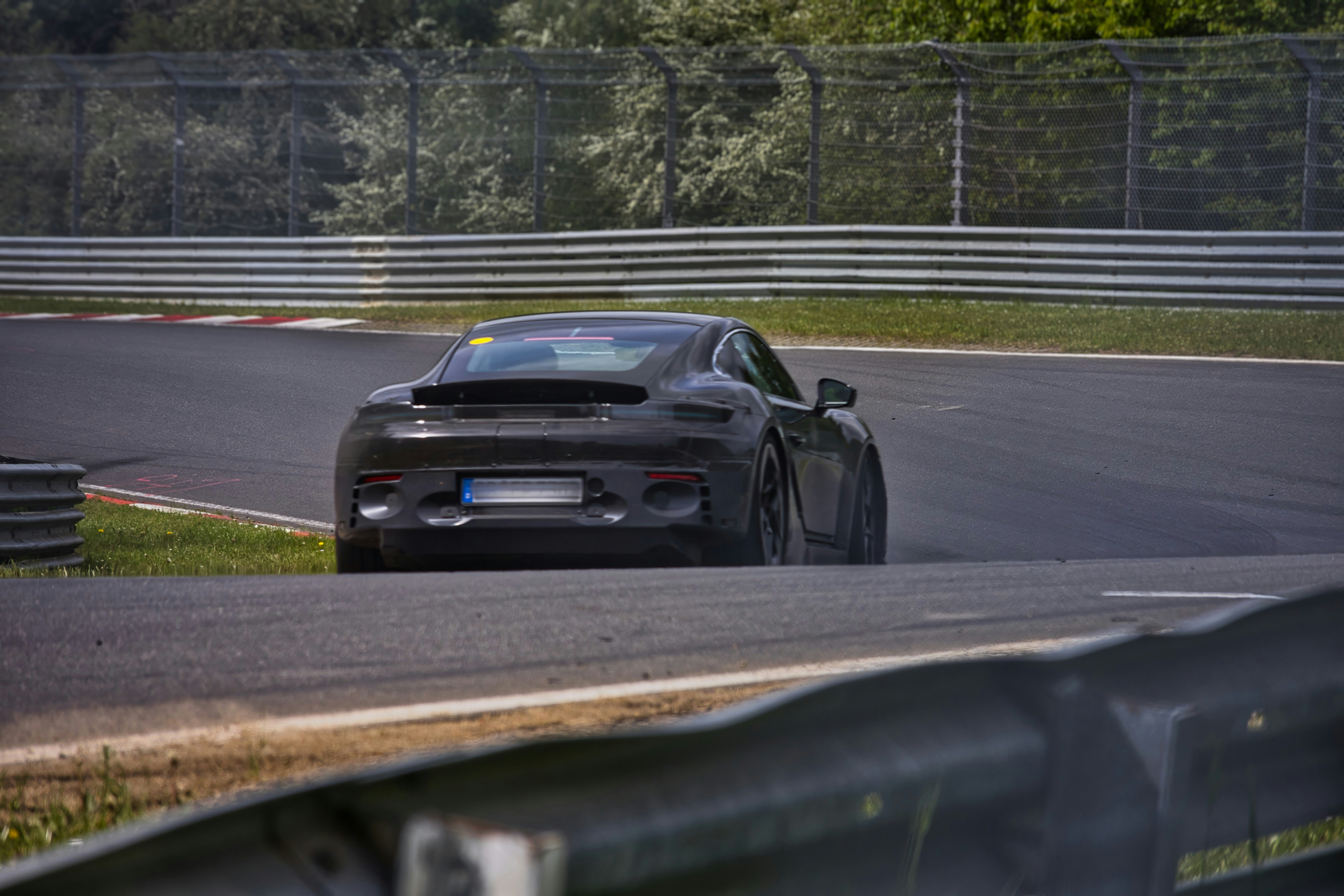 Dark sports car speeding on a race track.