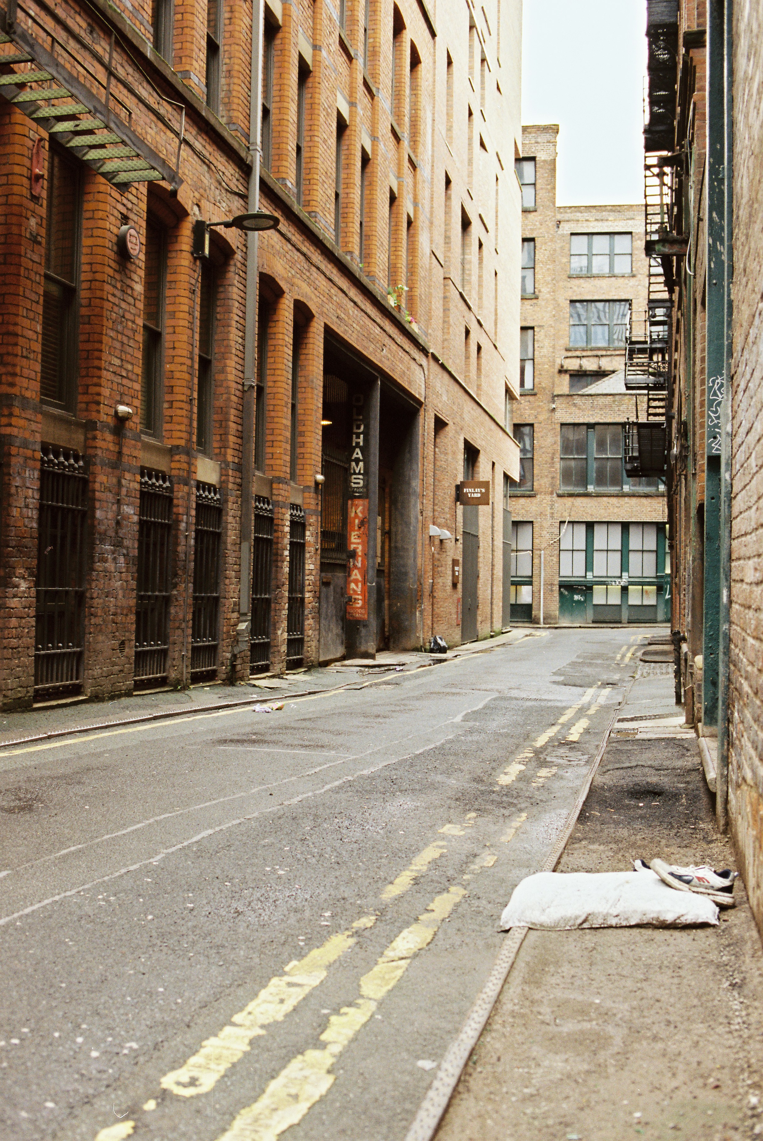 Sunlit Alleyway Between Brick Giants