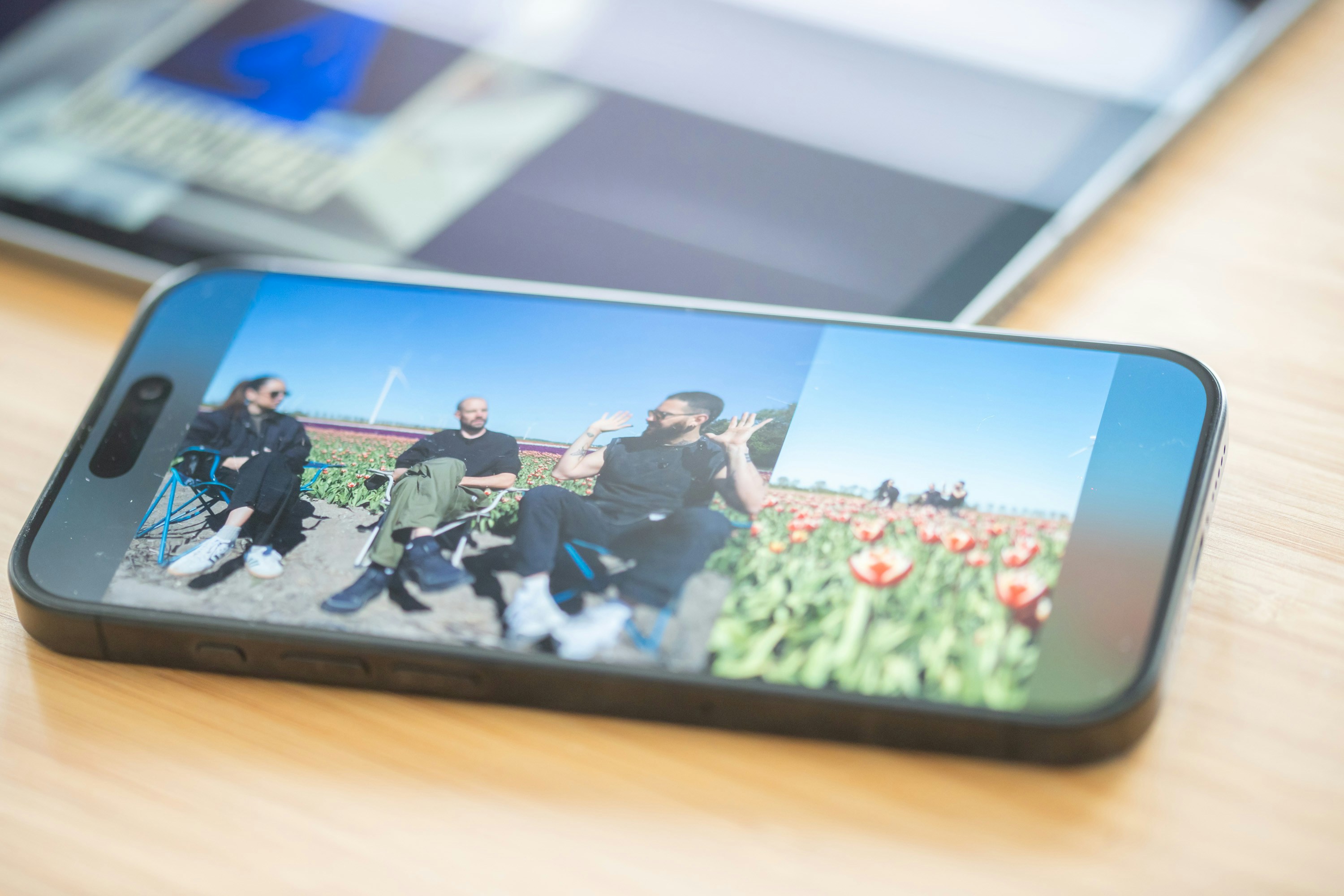 Group portrait across a tulip field captured on a handheld device