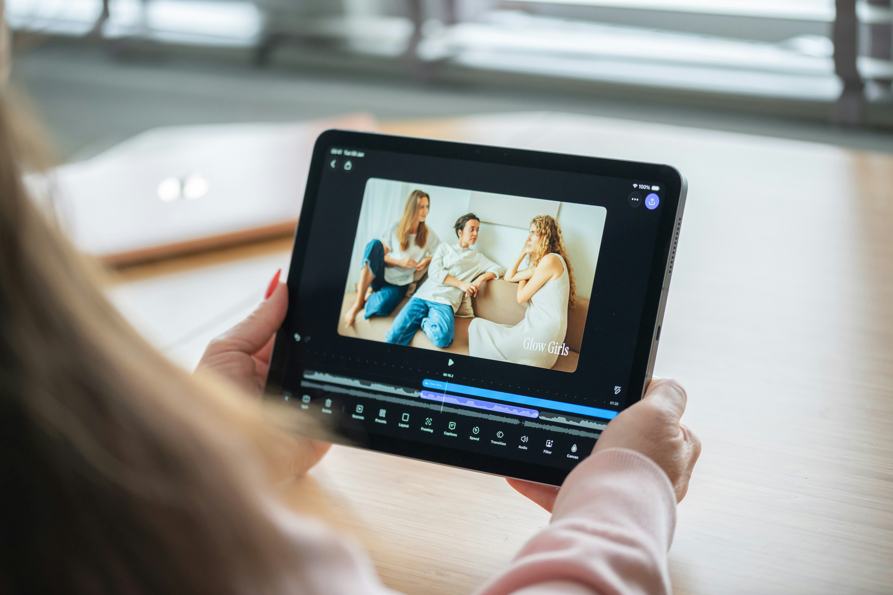 A tablet held in hands shows a family scene; foreground hands frame a video call or photo, with soft natural lighting and a warm, domestic setting. (Note: tablet display is a digital element; the image focuses on the device and content).