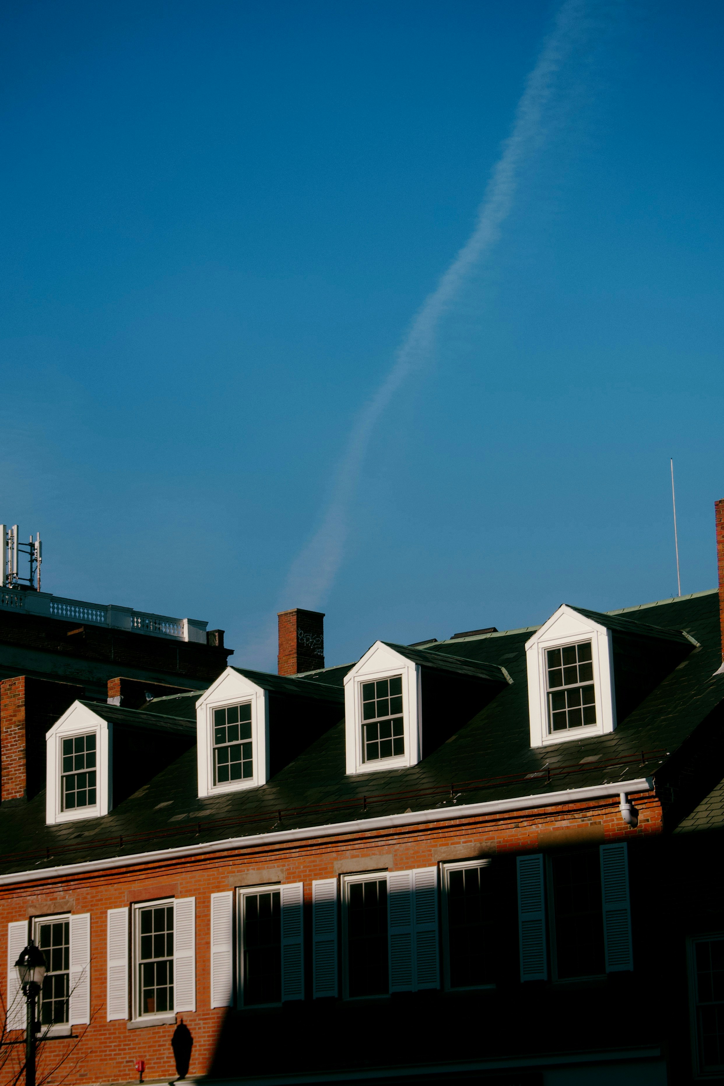 Brick Facade Under a Clear Blue Sky with Dormer Windows