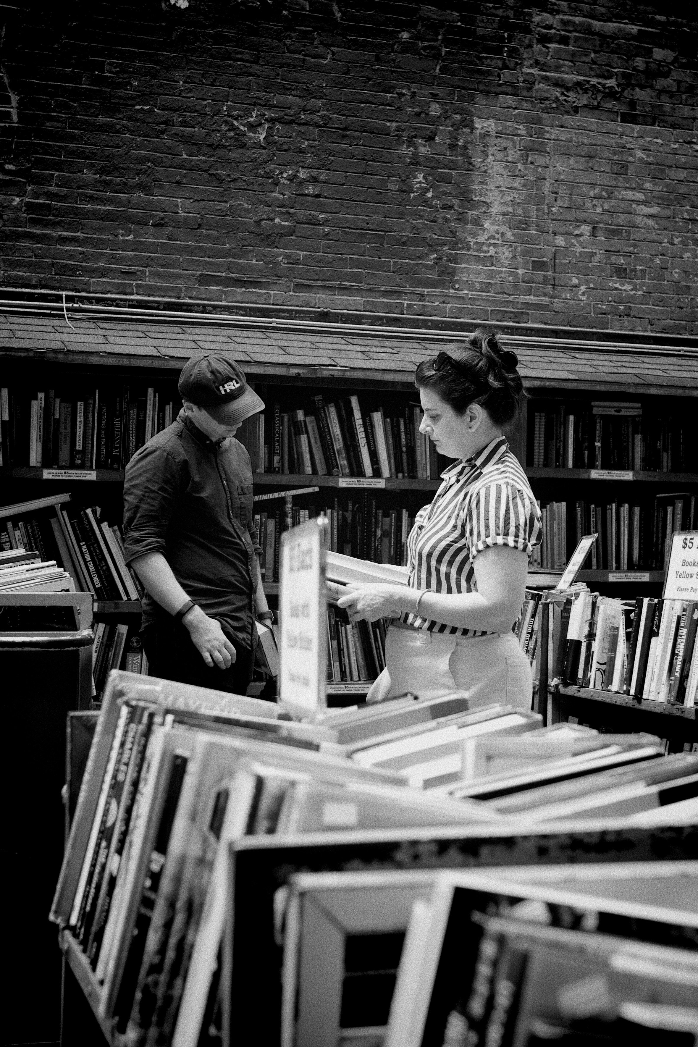 Two people browse books in a vintage bookstore.